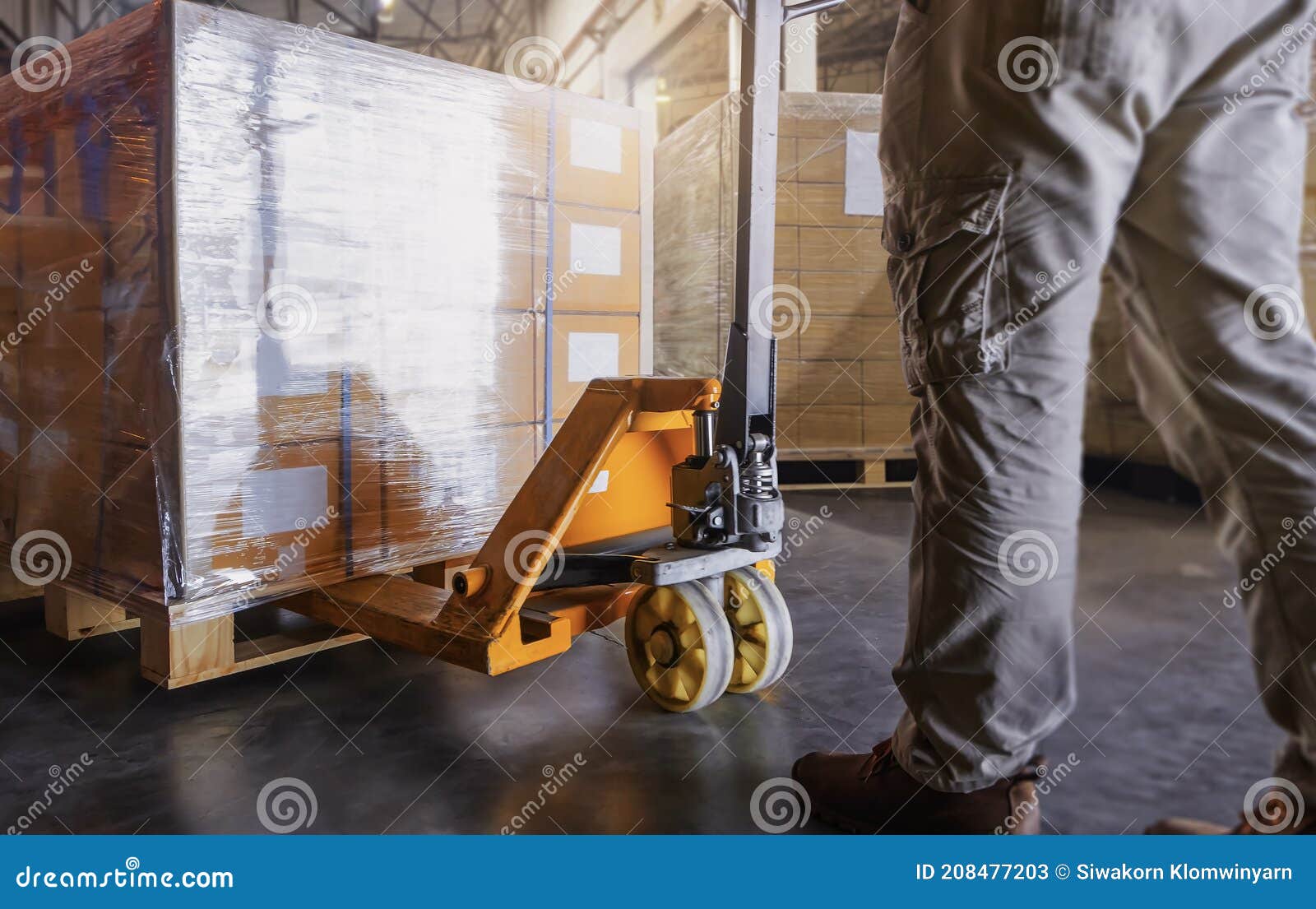 Warehouse Worker Working with Hand Pallet Jack Unloading Cargo Boxes at ...