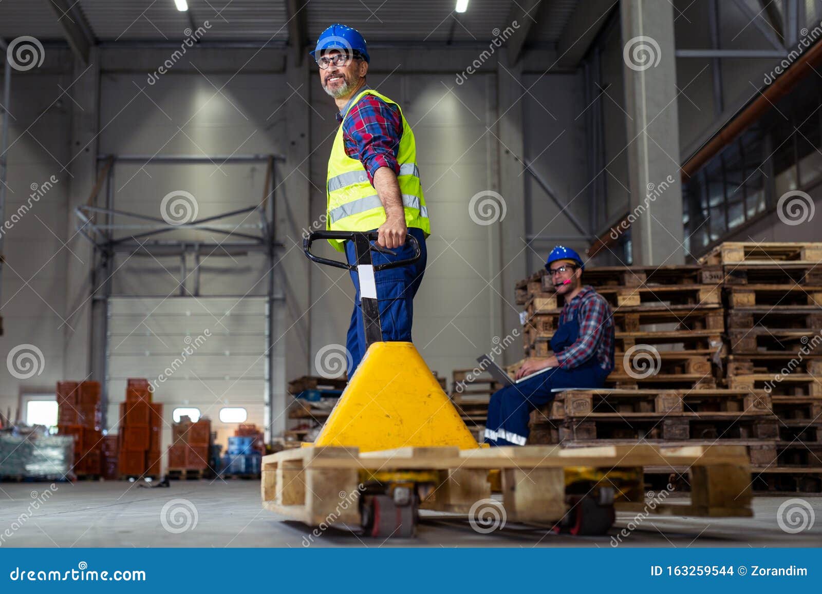 Warehouse Workers Pulling a Pallet Truck. Stock Photo - Image of ...