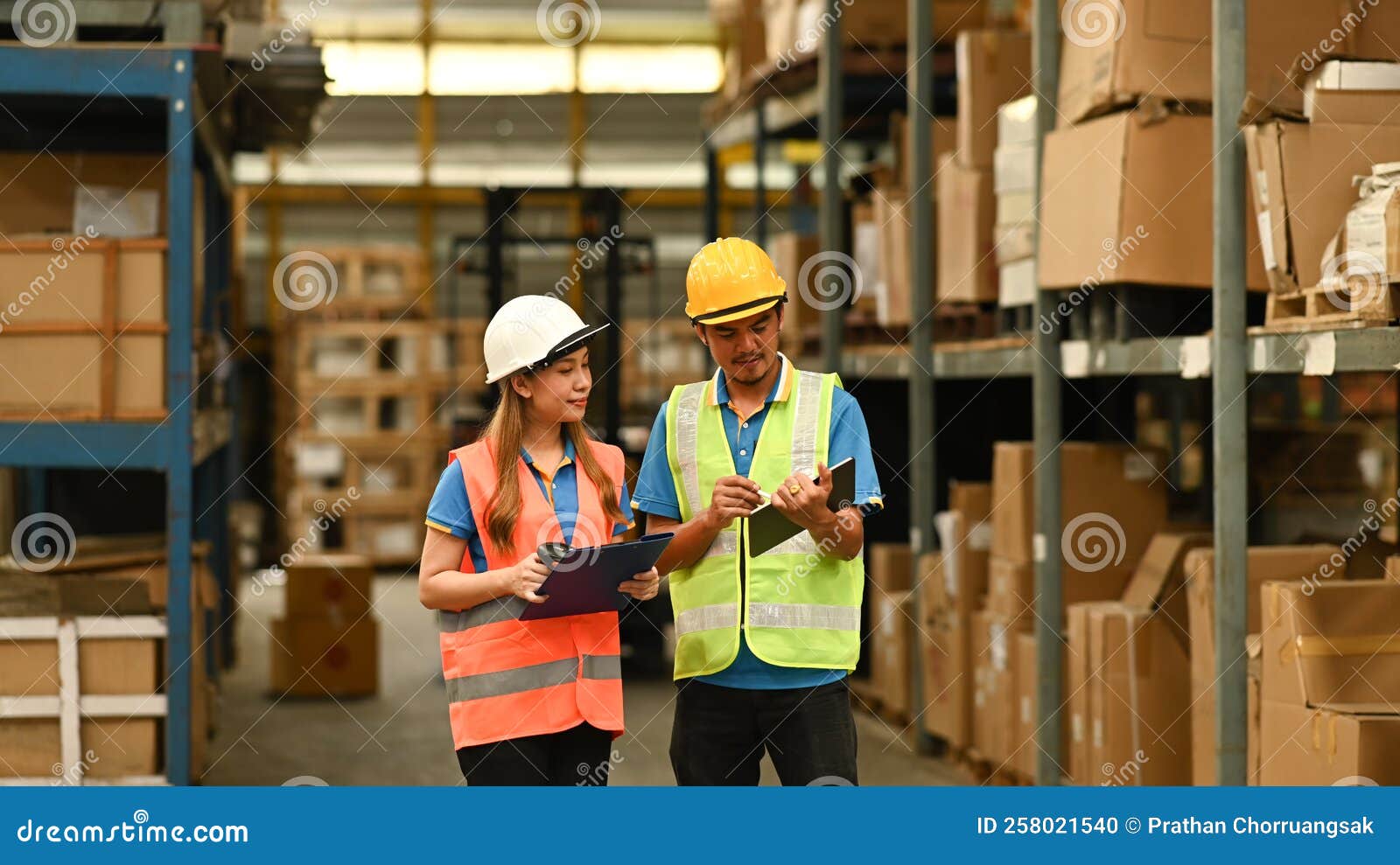 Warehouse Workers Wearing Safety Hardhat Discussing Work while Walking ...