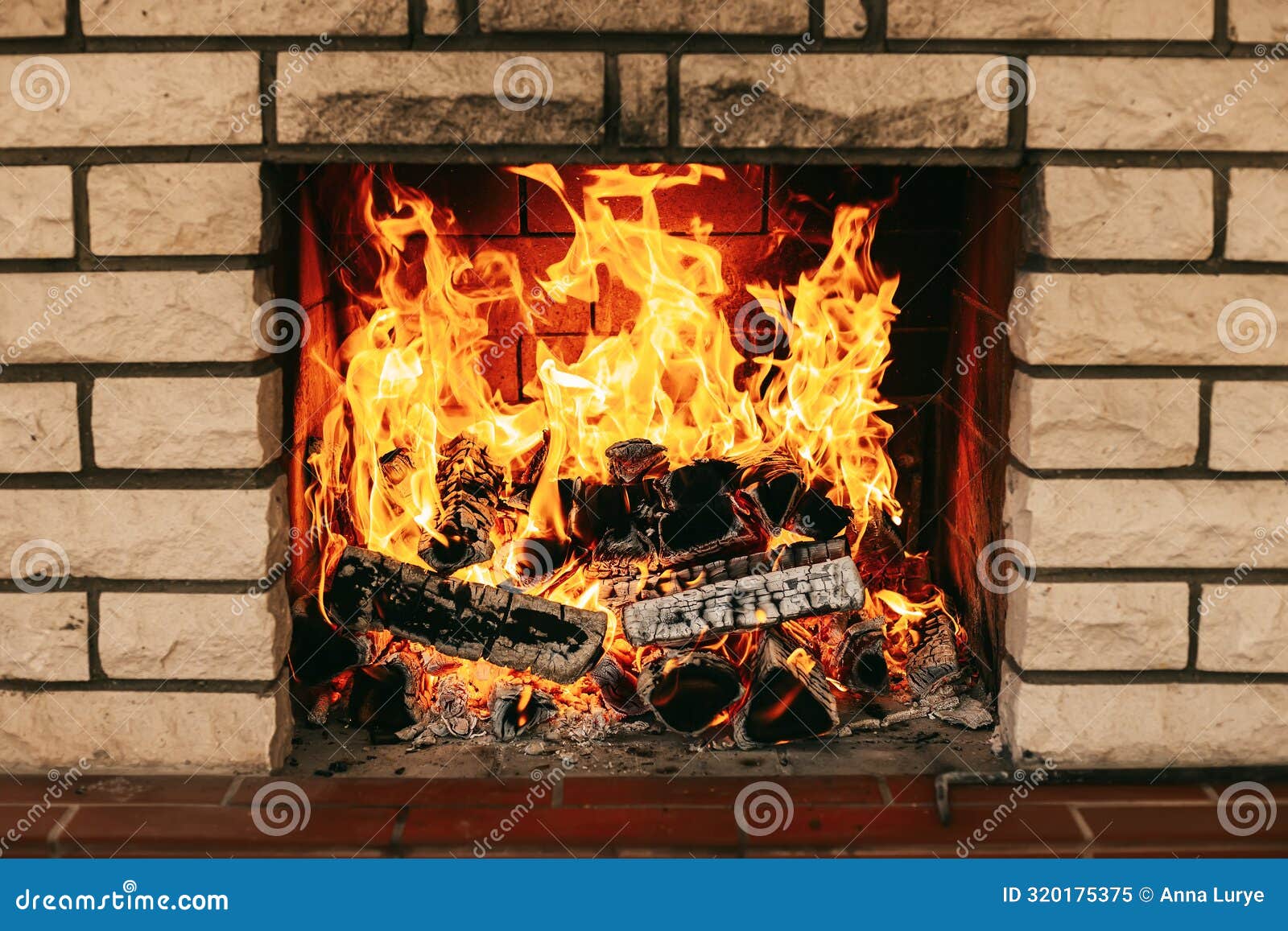 A Warm, Roaring Fire in a Fireplace Embedded in a Light Brick Wall ...