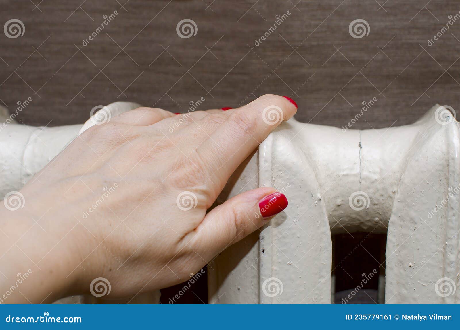 Warming Hand on Heating Radiator. Heating of a Residential Building in ...