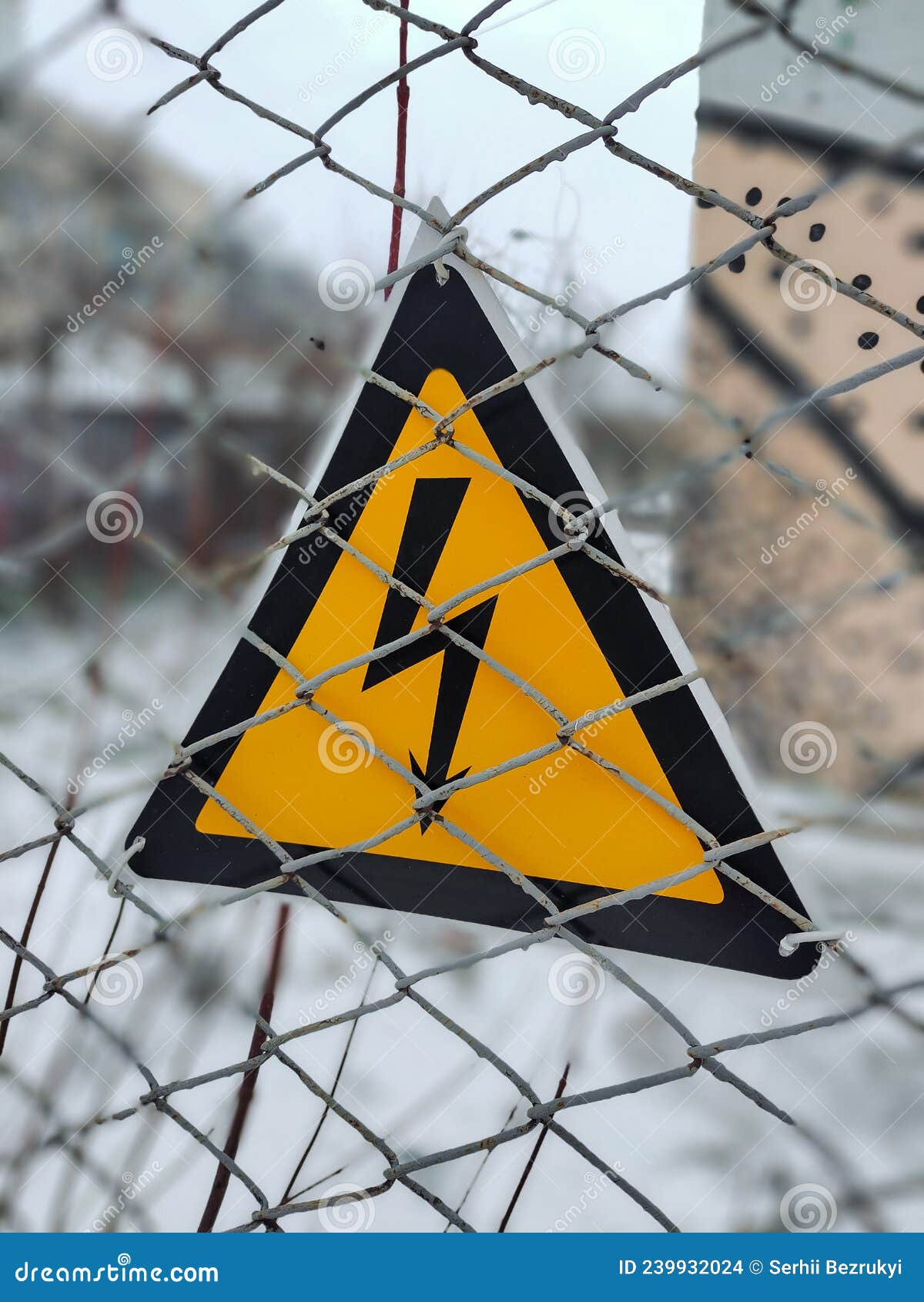 A Warning Sign Hangs on a Wire Fence about High Electrical Voltage ...