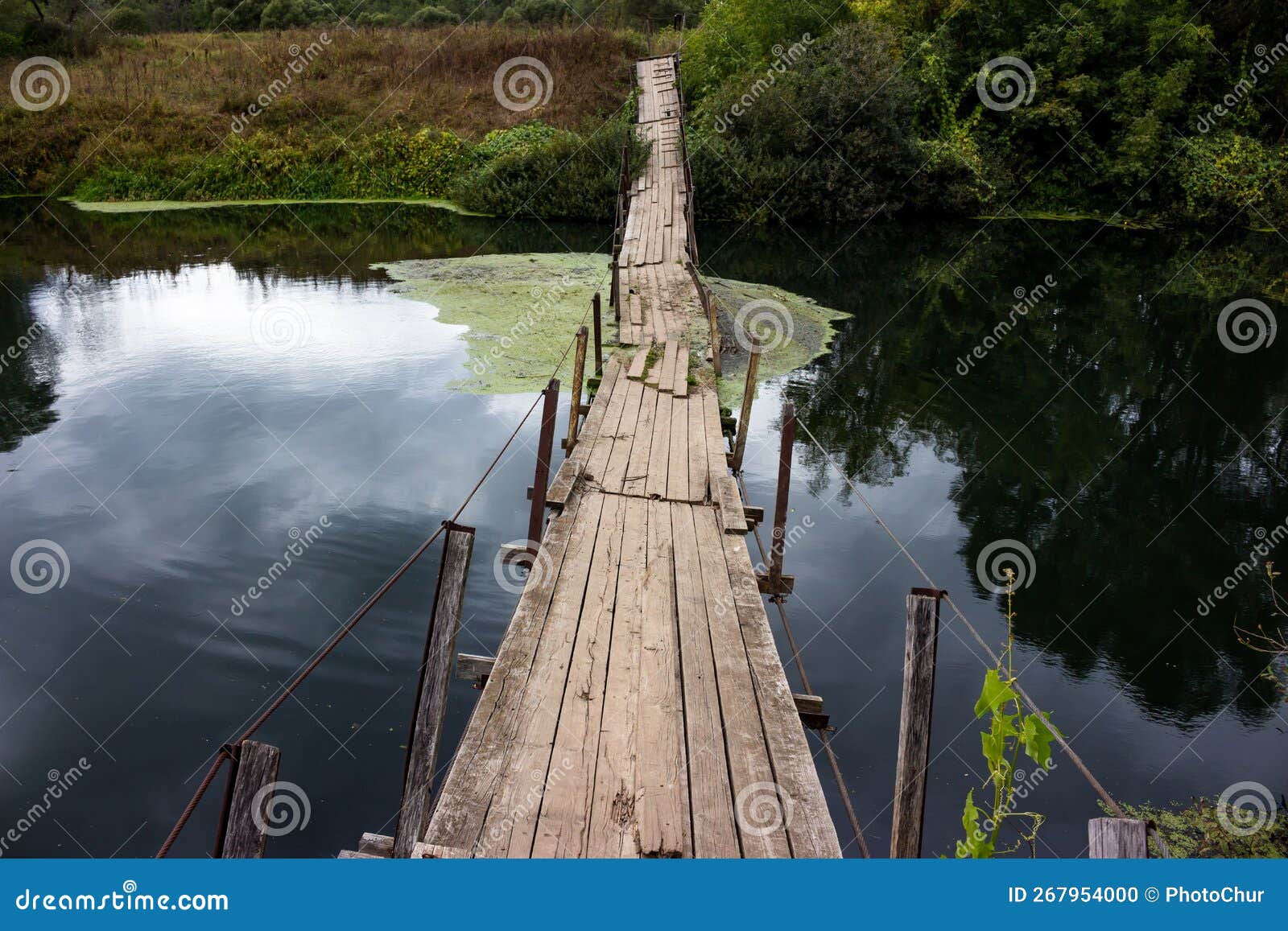 Warped and Lying on the Water Footbridge Across the River Stock Photo ...