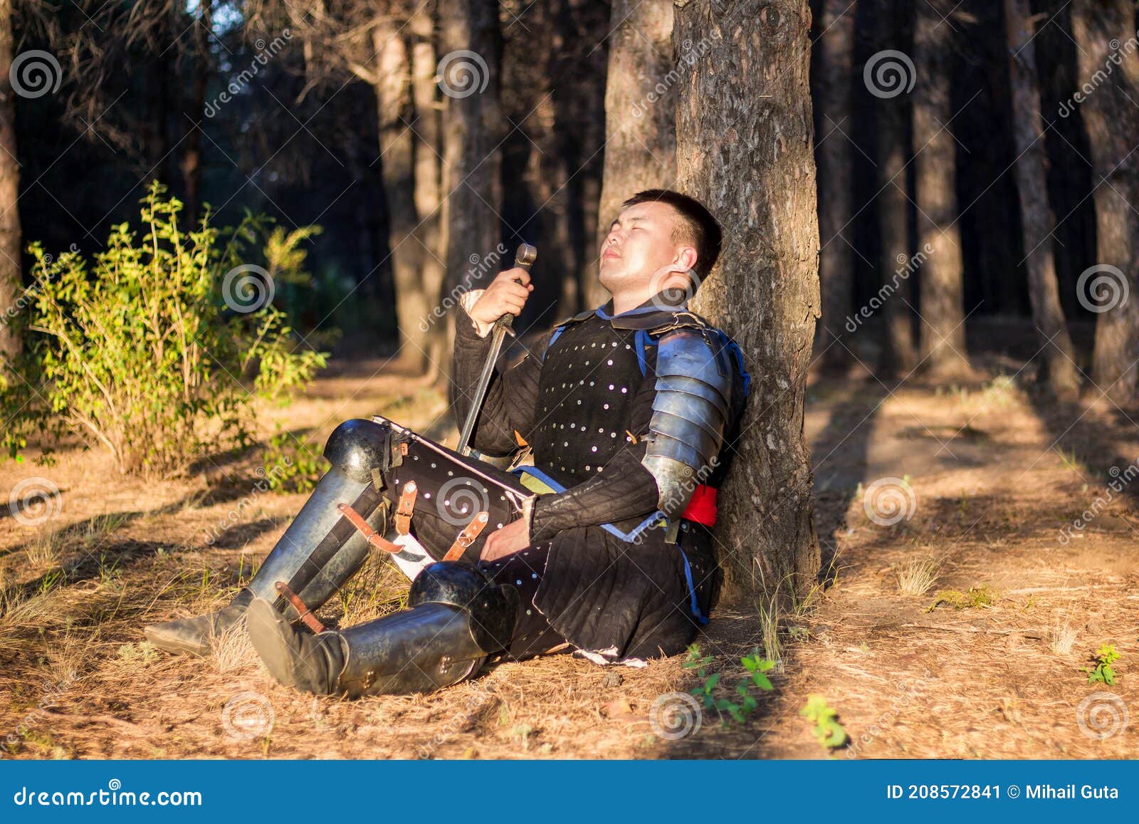 Warrior In Black Armor With A Sword In His Hands Is Leaning Against A ...