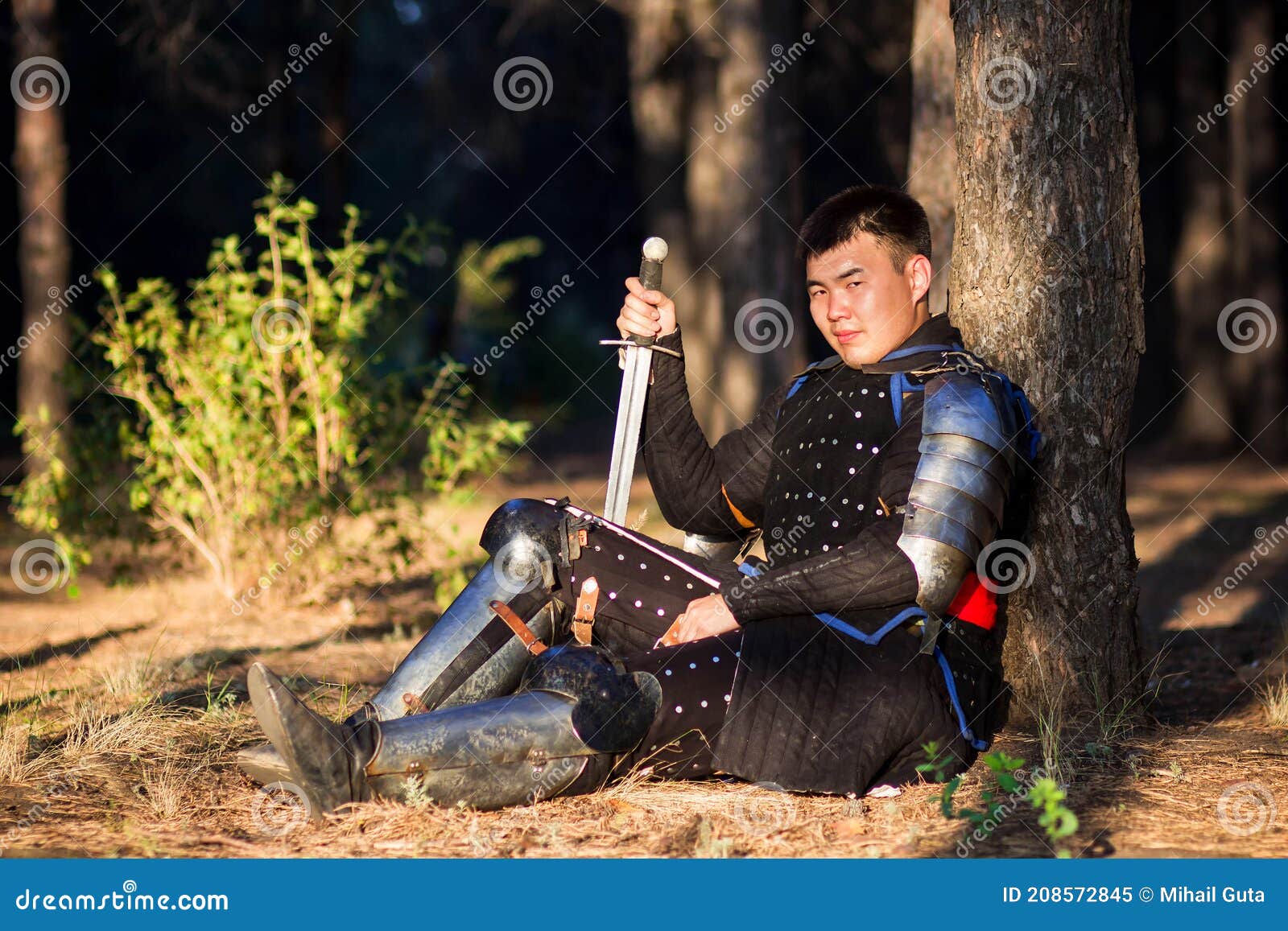 Warrior In Black Armor With A Sword In His Hands Is Leaning Against A ...