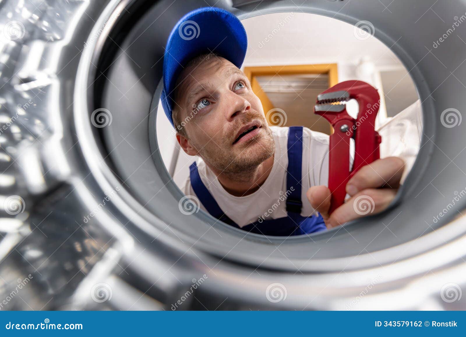 Washing Machine Repair Service. Repairman Looking Inside Drum Stock ...