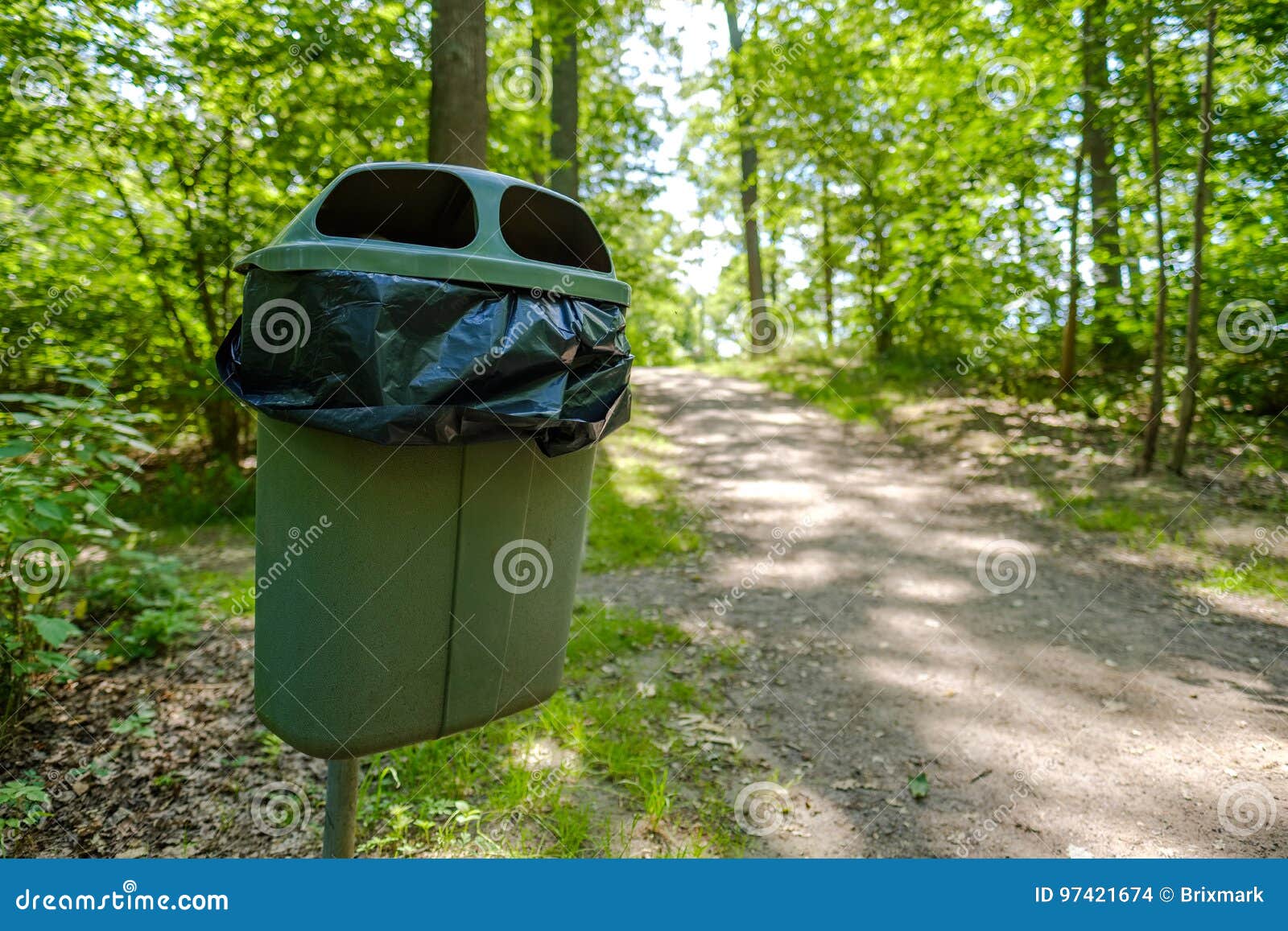 Waste bin by a forest path stock photo. Image of holes - 97421674