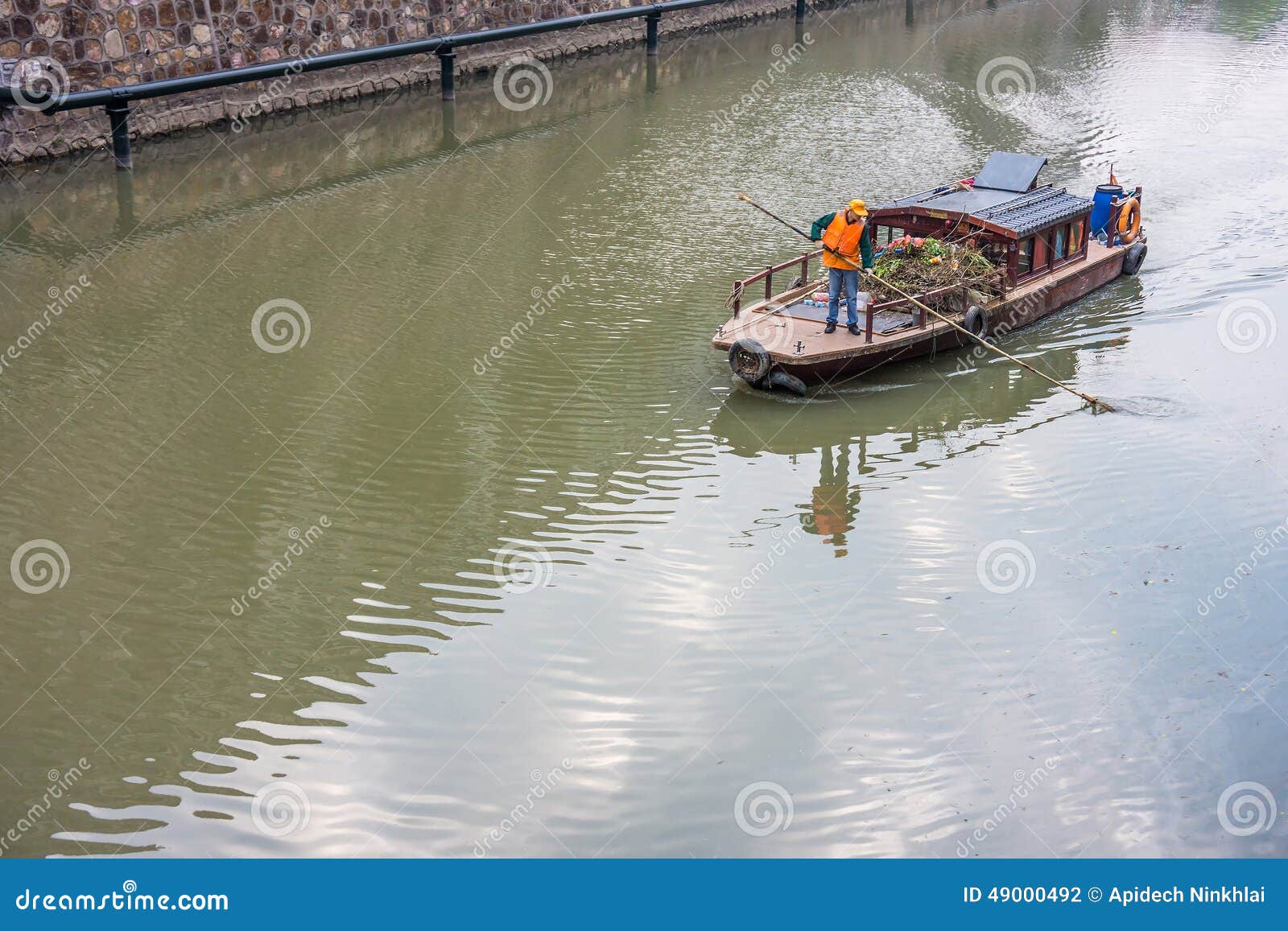 A Waste Collector is Collecting Refuse from a River Editorial ...