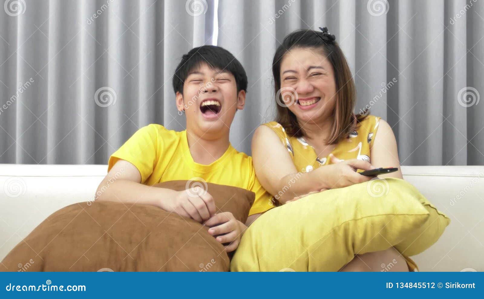 Watching Tv Lying On The Couch Asian Mom And Son Watch Tv Together And Smile Mom Switches