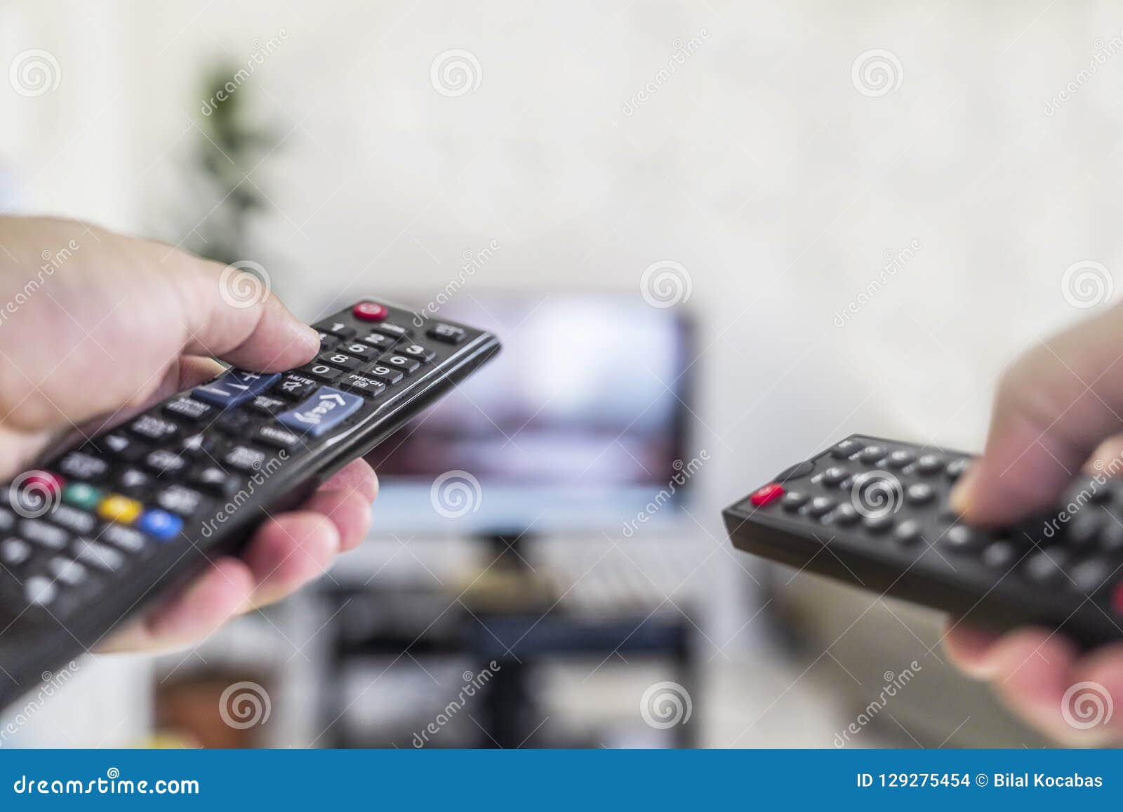 Watching Tv and Using Two Remote Control Stock Photo - Image of digital ...