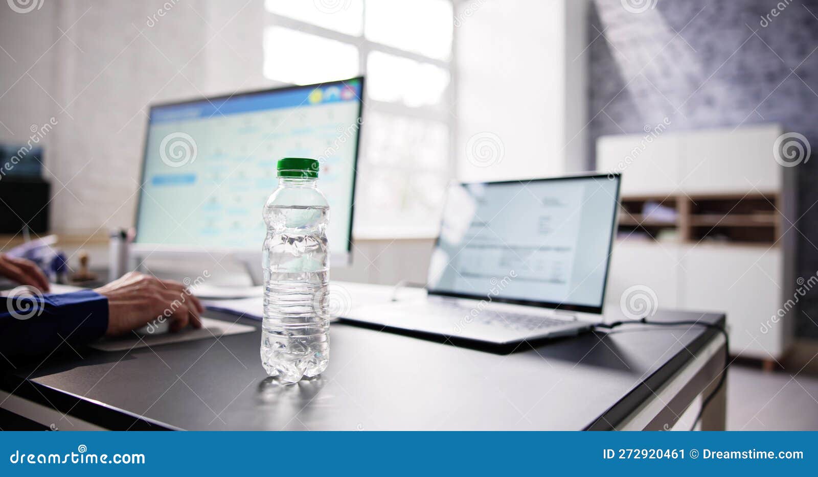 Water Bottle on Desk and Man in Background Stock Image - Image of ...