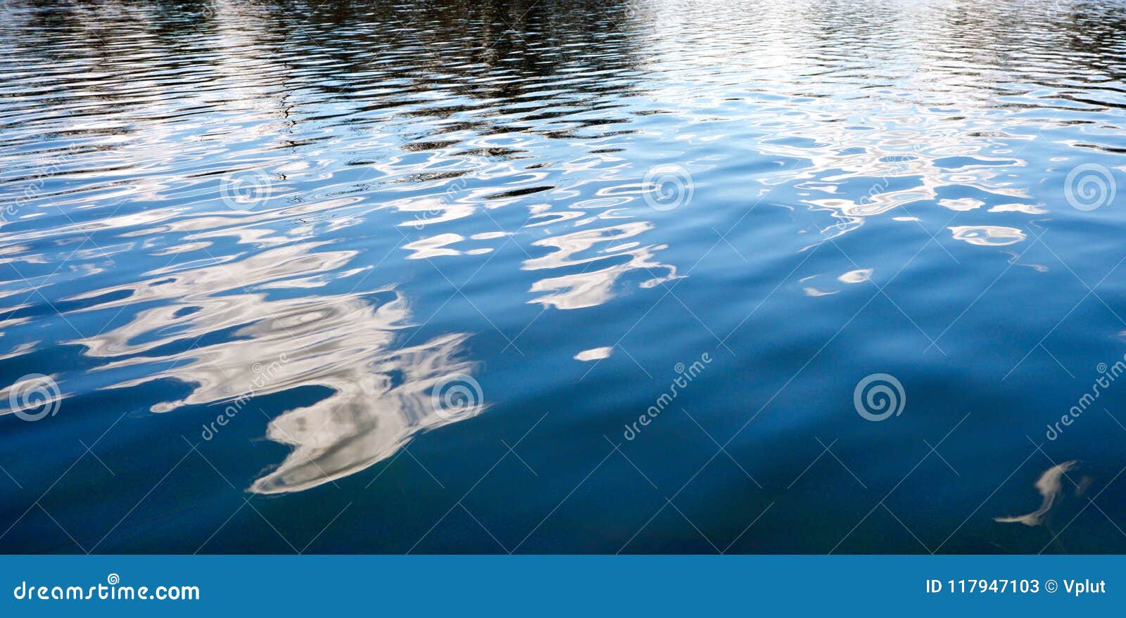 Water with Distorted Reflections of Clouds and Shore Stock Image ...