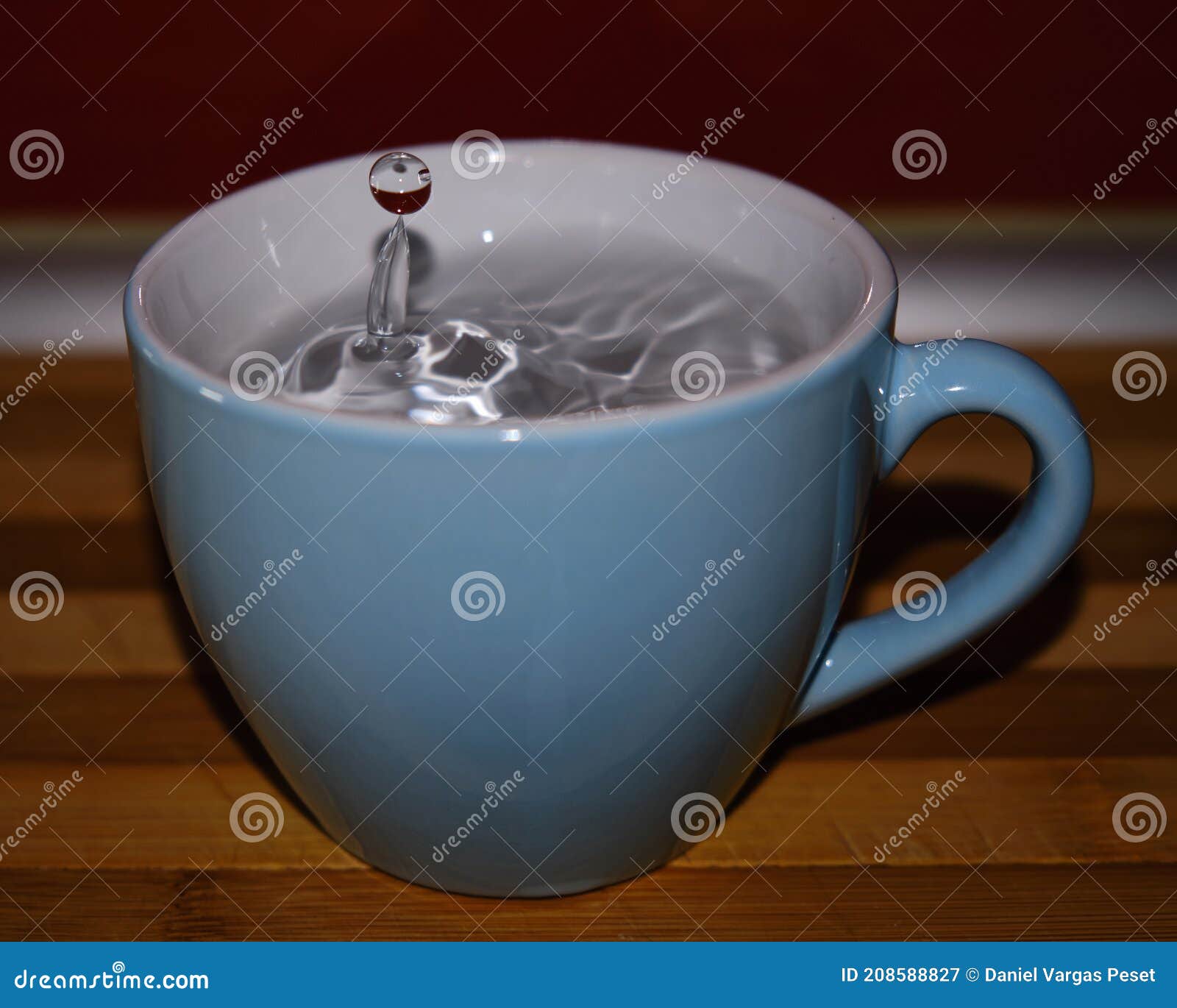 Water Drop Falling into a Blue Mug Over a Red Background Stock Image ...