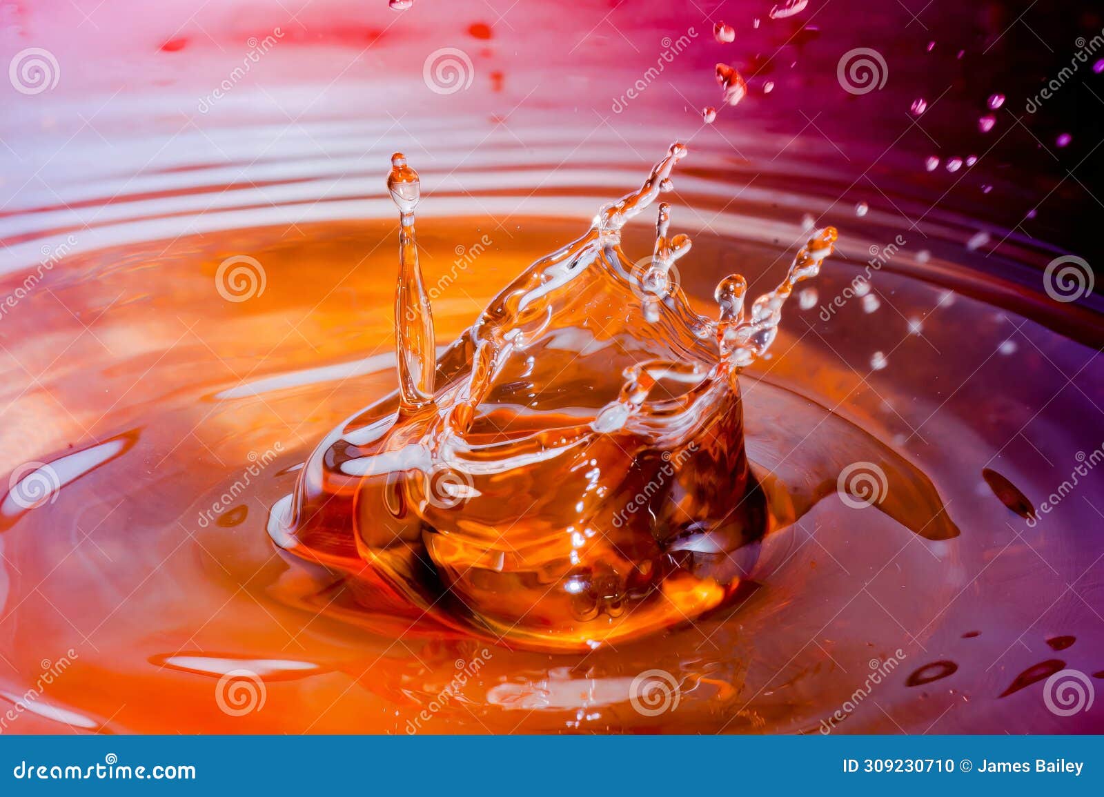 Water Droplet Causes a Splash in Multi-coloured Water Stock ...