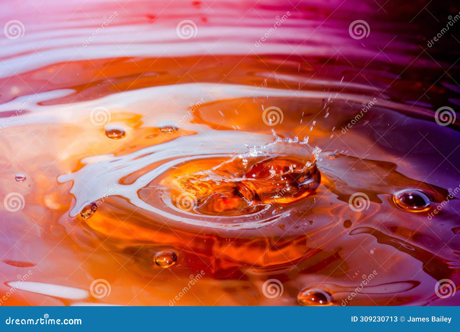 Water Droplet Causes a Splash in Multi-coloured Water Stock ...