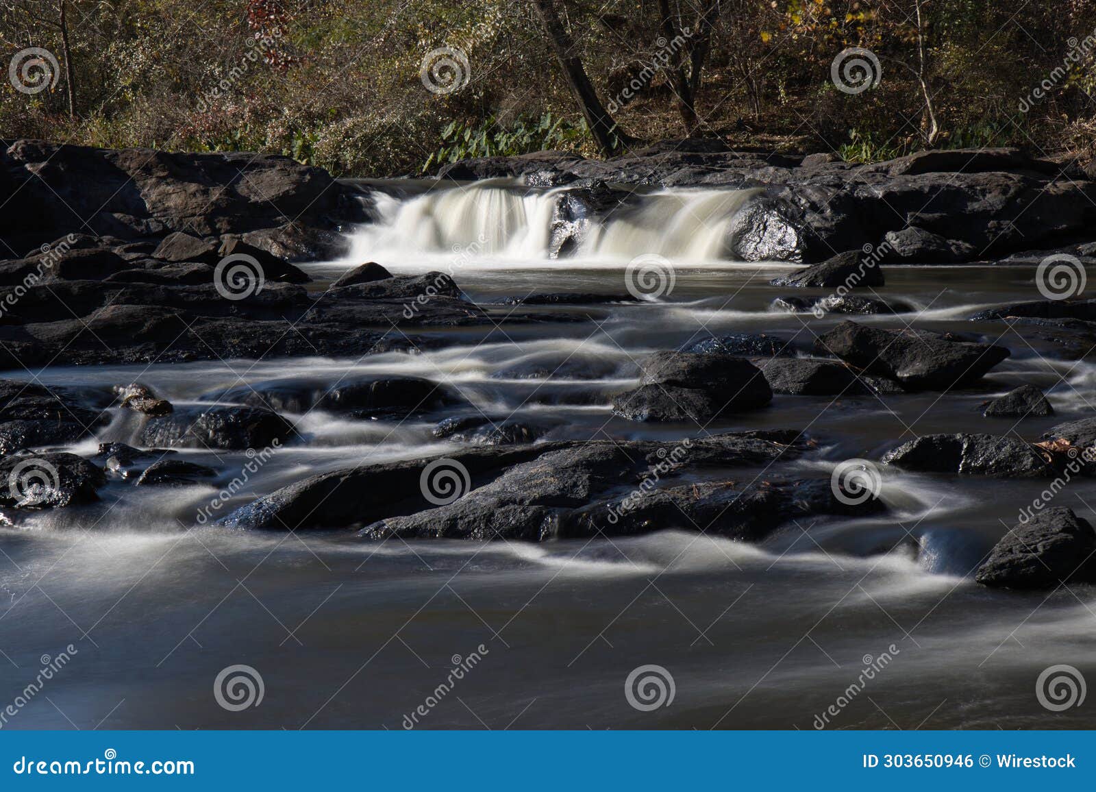 Water Flowing Over Rocks Downstream from a Waterfall on a Gorgeous ...