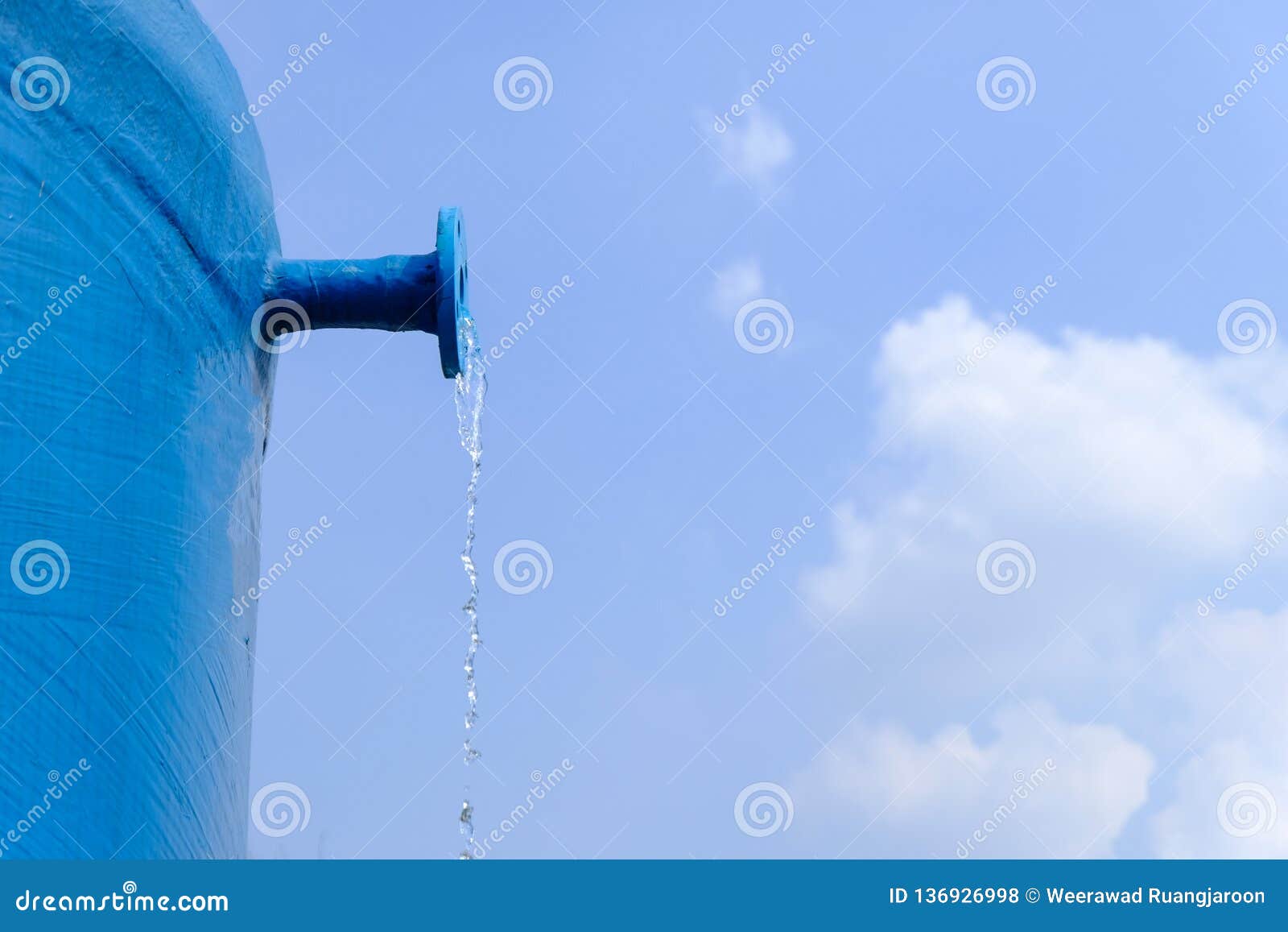 Water Flows from Blue Water Tank on Sky Backgrounds. Stock Photo ...
