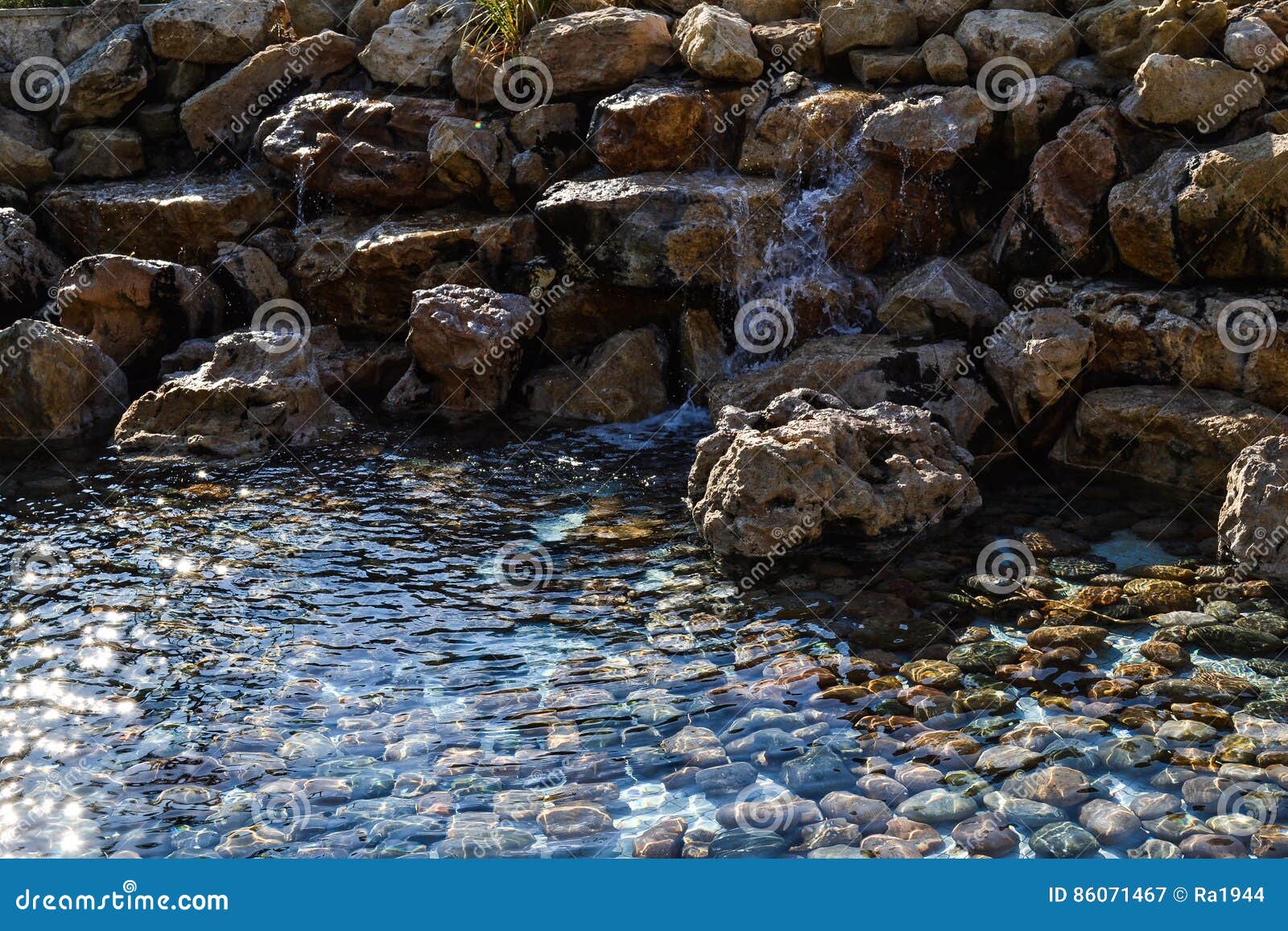 Water Flows Over the Rocks into the Pool with Stones at the Bottom ...