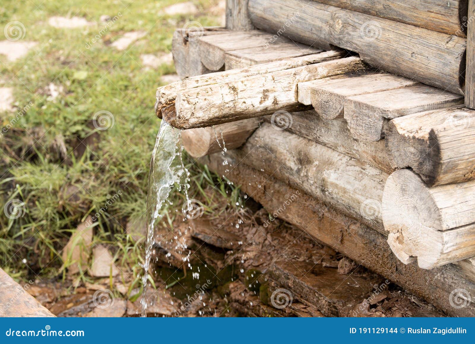 Water Flows from the Spring through a Wooden Pipe. Summer Day Stock ...
