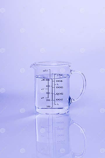 Water in a Measuring Container on a Light Blue Background Stock Photo ...