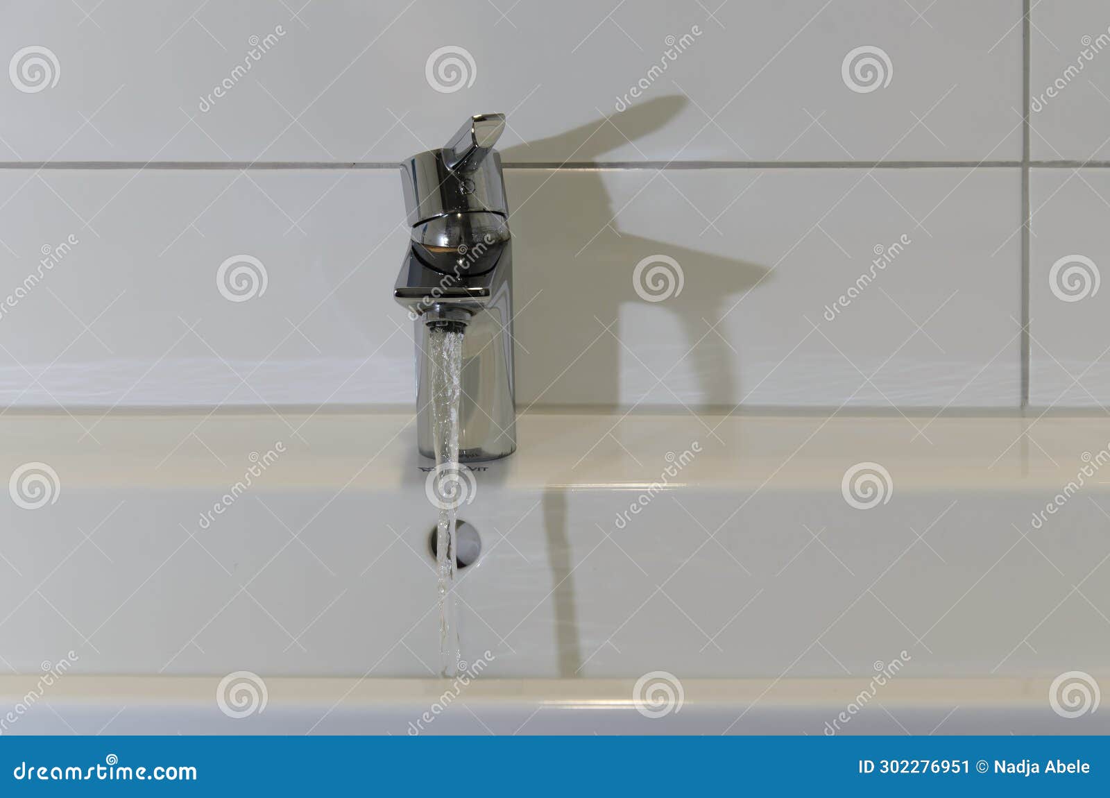 Water Pouring from Faucet into Sink and Harsh Shadow of Them. Stock ...