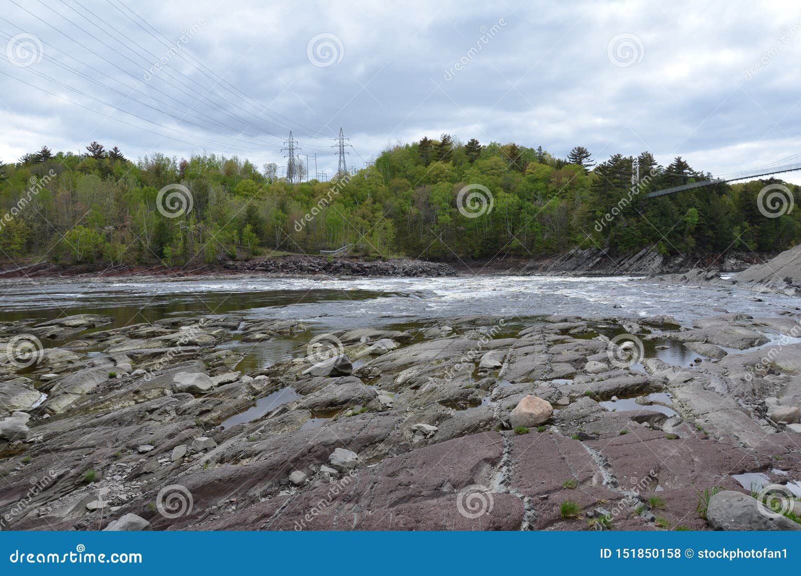 Water and Riverbed with Grey and Red Rocks and Bridge Stock Photo ...