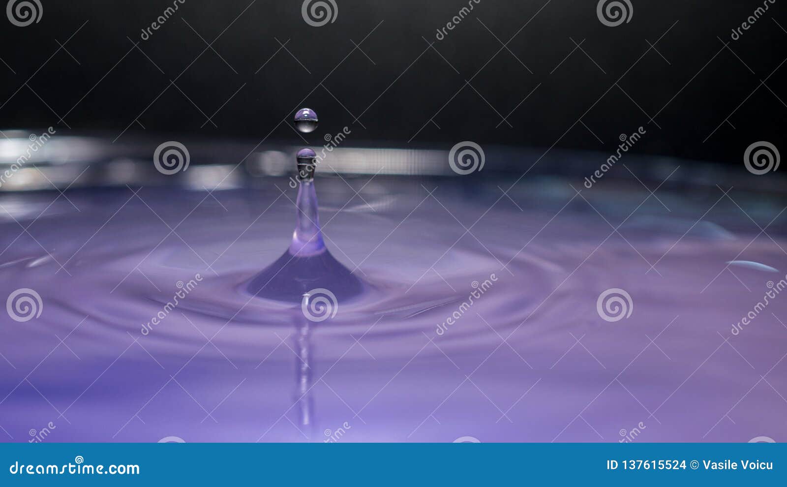 Water Splash in Colorful Background with a Drop of Water Flying from ...