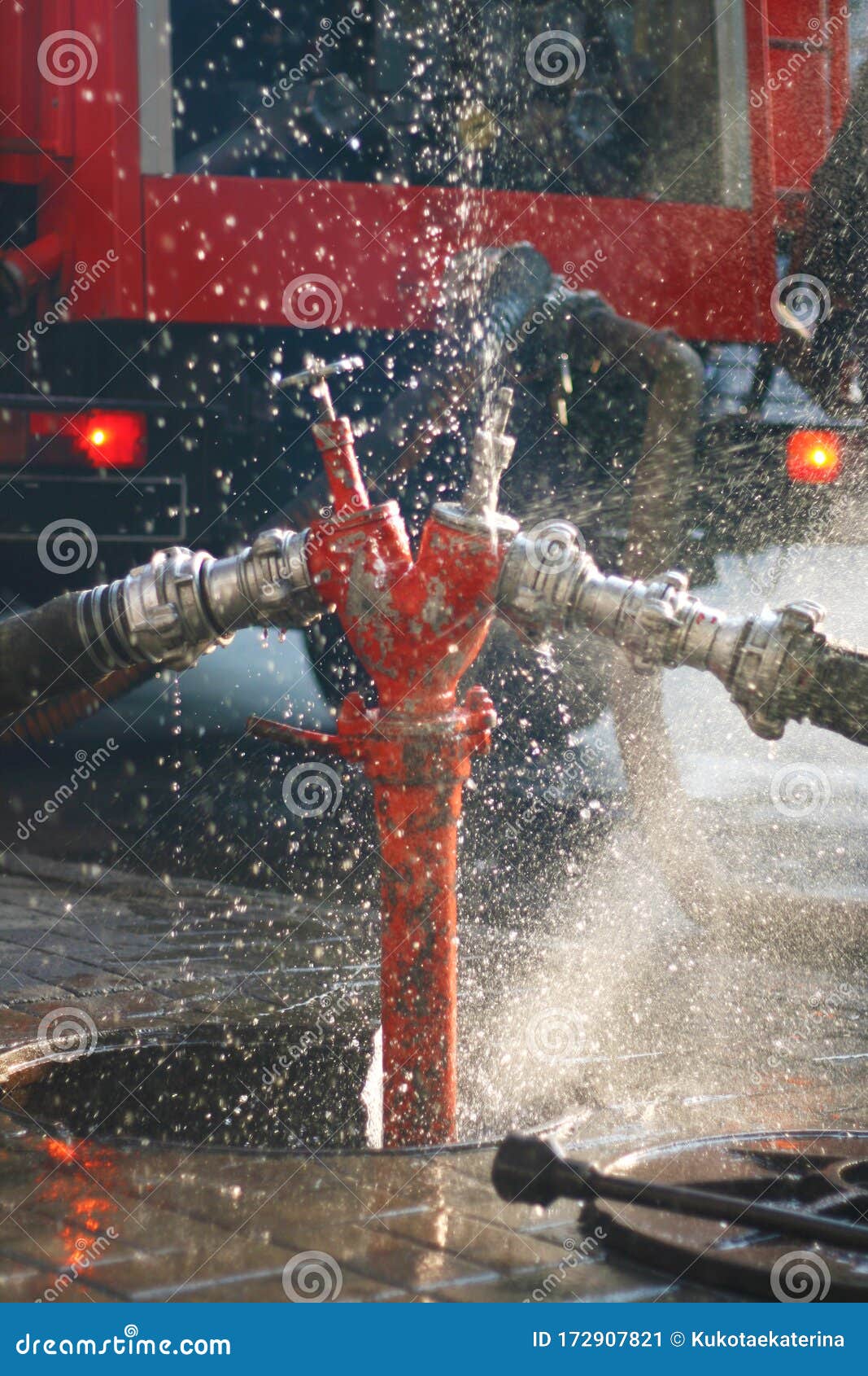 Water Splashes from the Fire Hose and Hydrant Connections. Firefighters ...