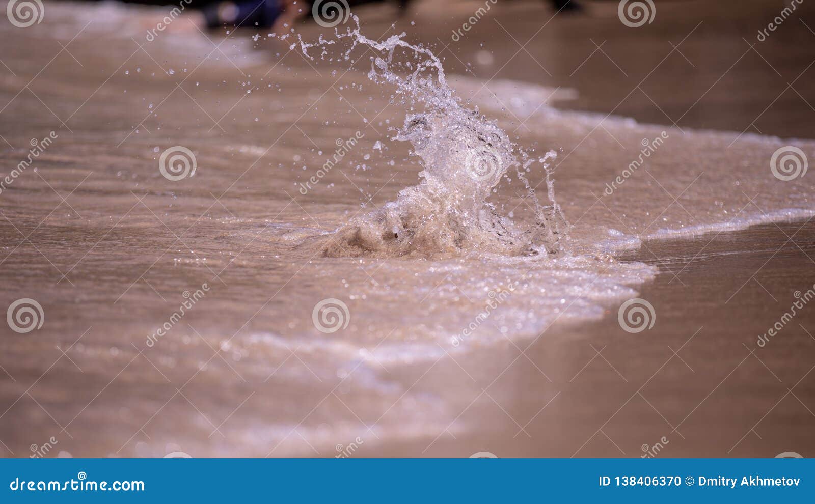 Water Splashing Over a Small Stone on a Sand Beach Stock Photo - Image ...