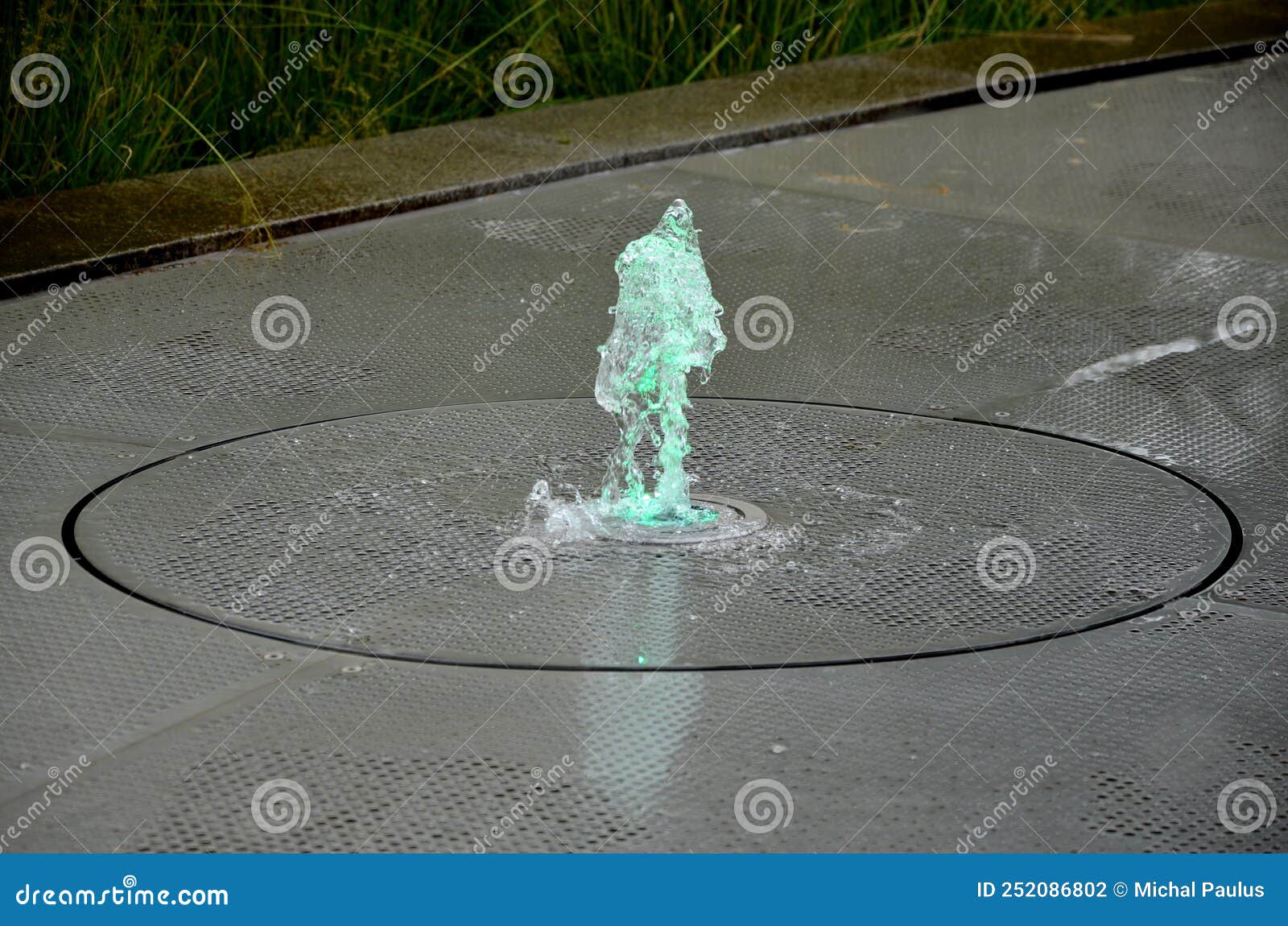 Water Sprays Backlit by Colored Lights Alternating at Night with a ...