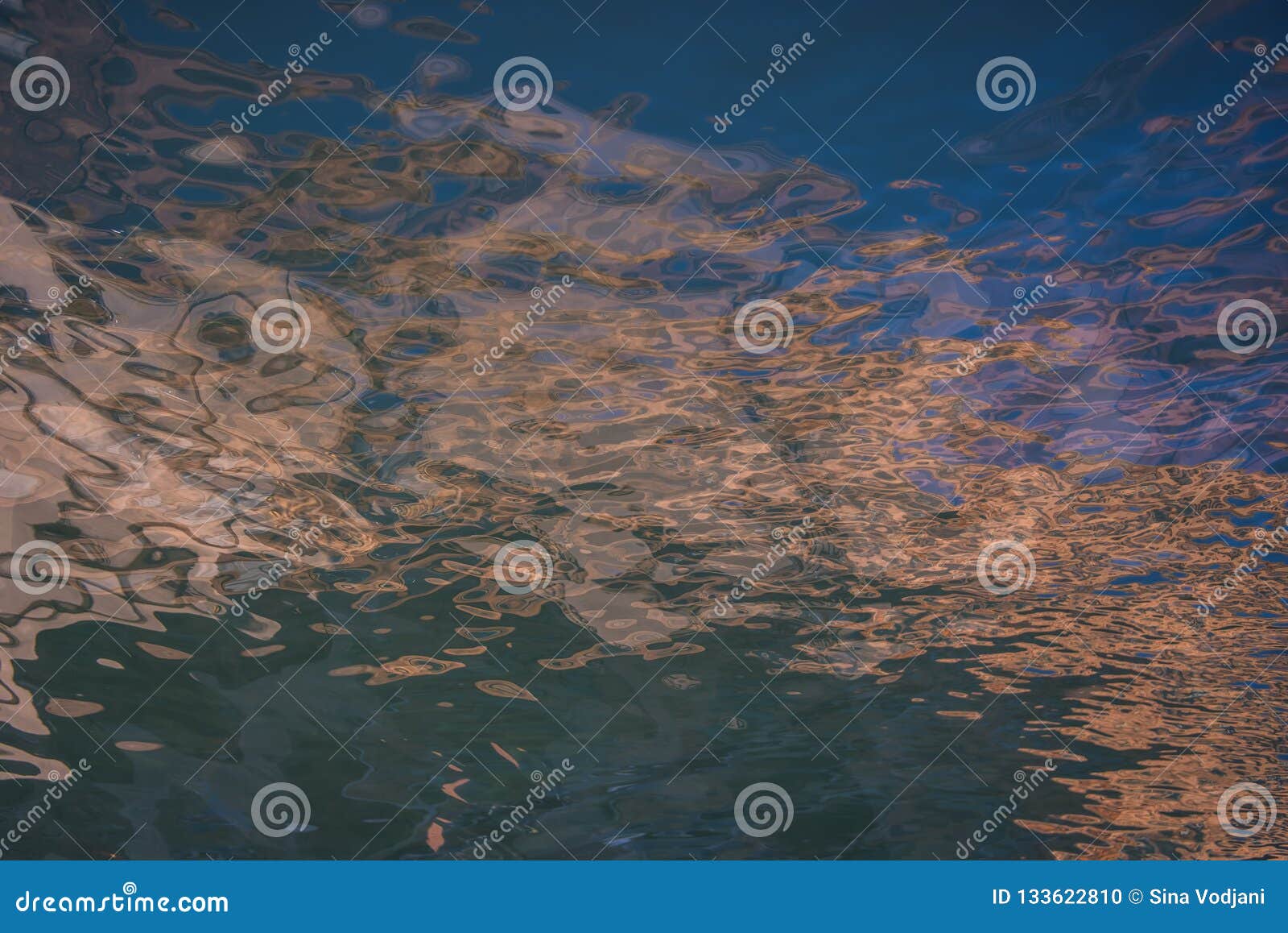 Water Surface with Wave Ripples and Orange Reflection Stock Photo ...