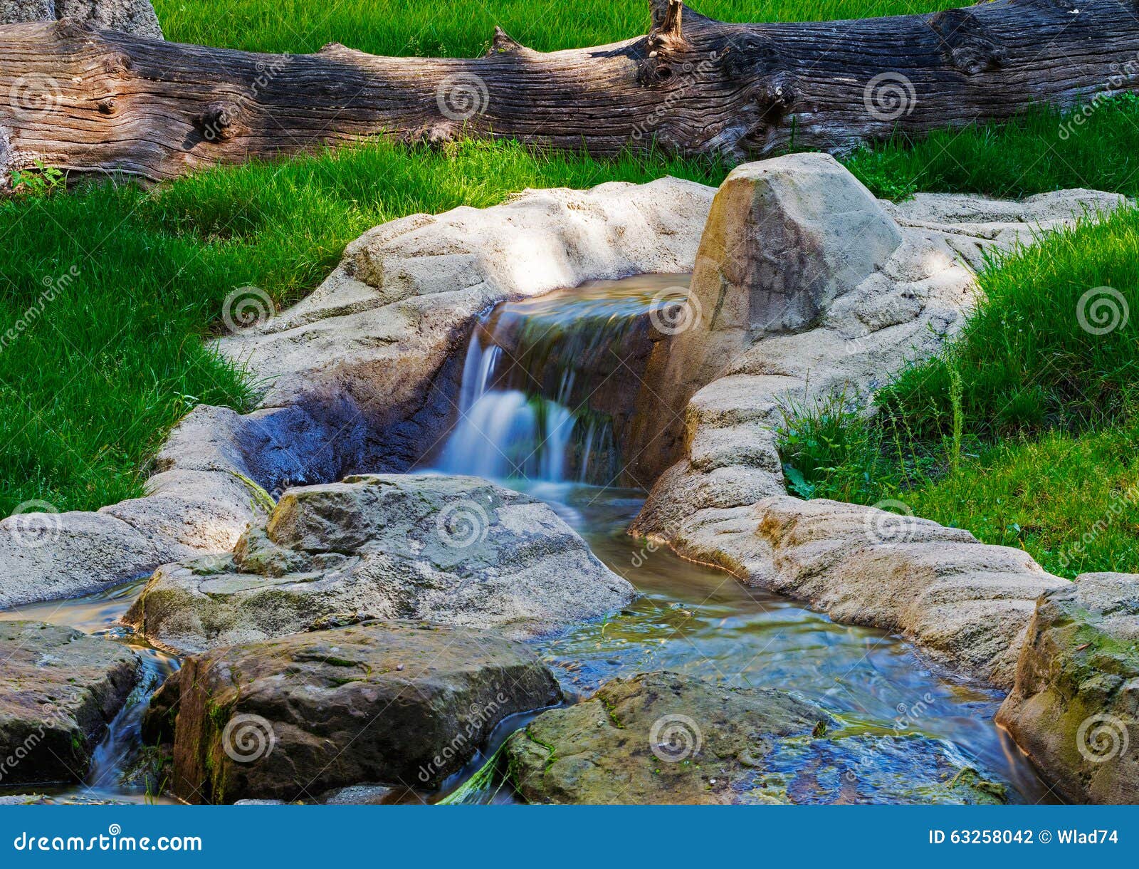 Waterfall on the Creek Flowing through Green Grass Stock Photo - Image ...