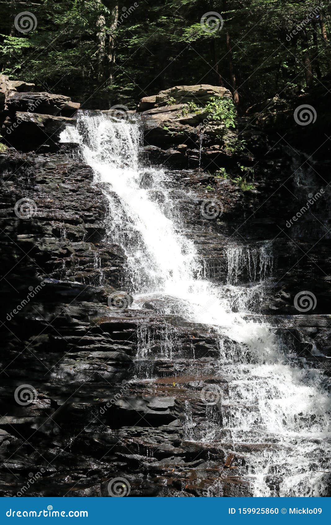 Waterfall over the rocks stock photo. Image of sunlight - 159925860