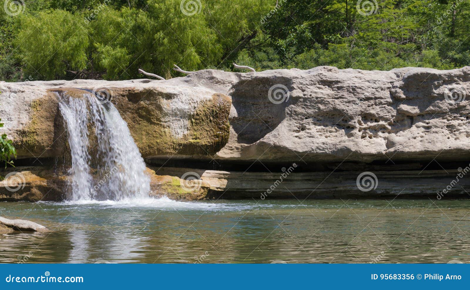 A Waterfall Flowing Over Different Layers of Rock Stock Photo - Image ...