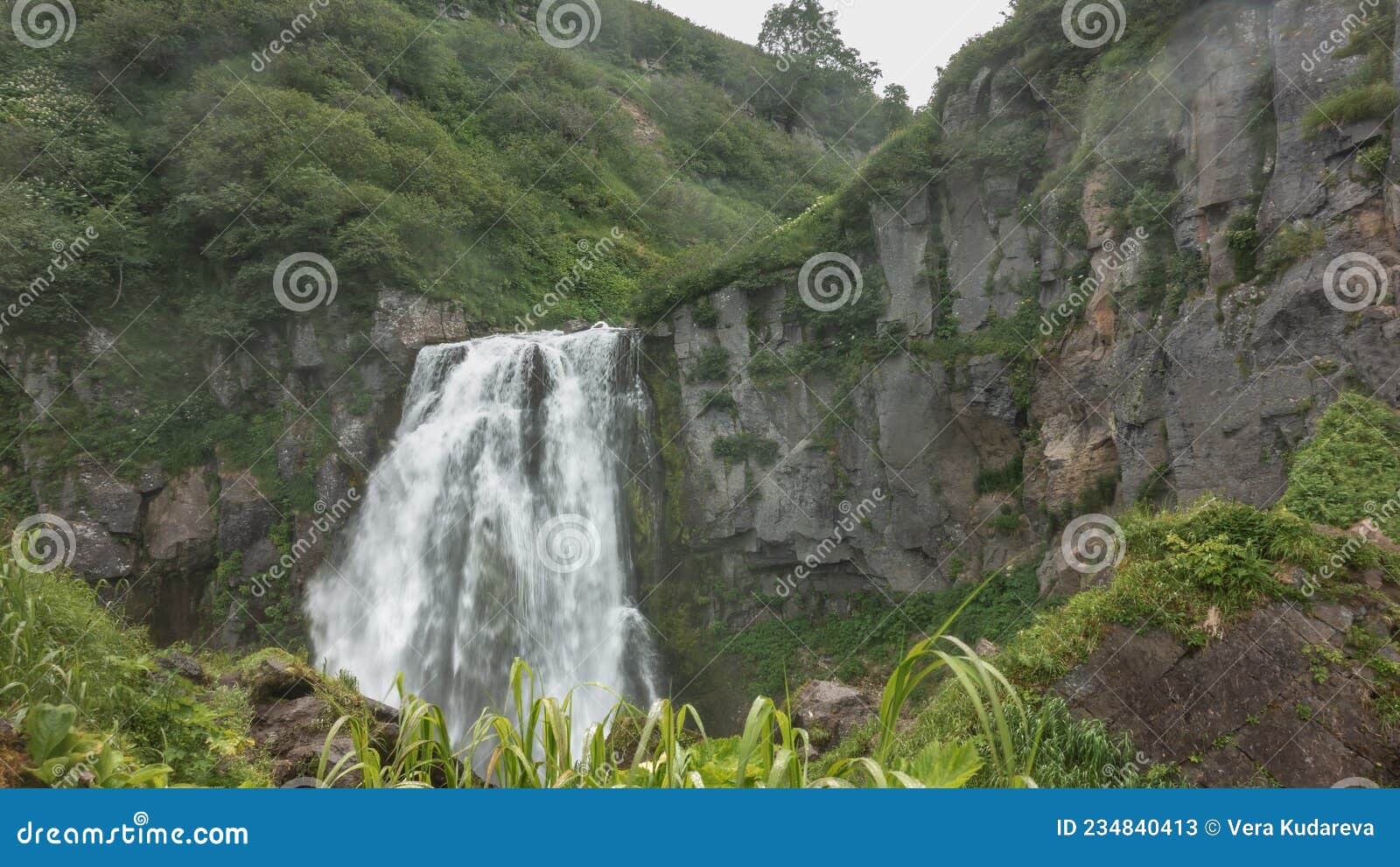 The Waterfall Flows Down from the Steep Rocky Slope of the Mountai ...