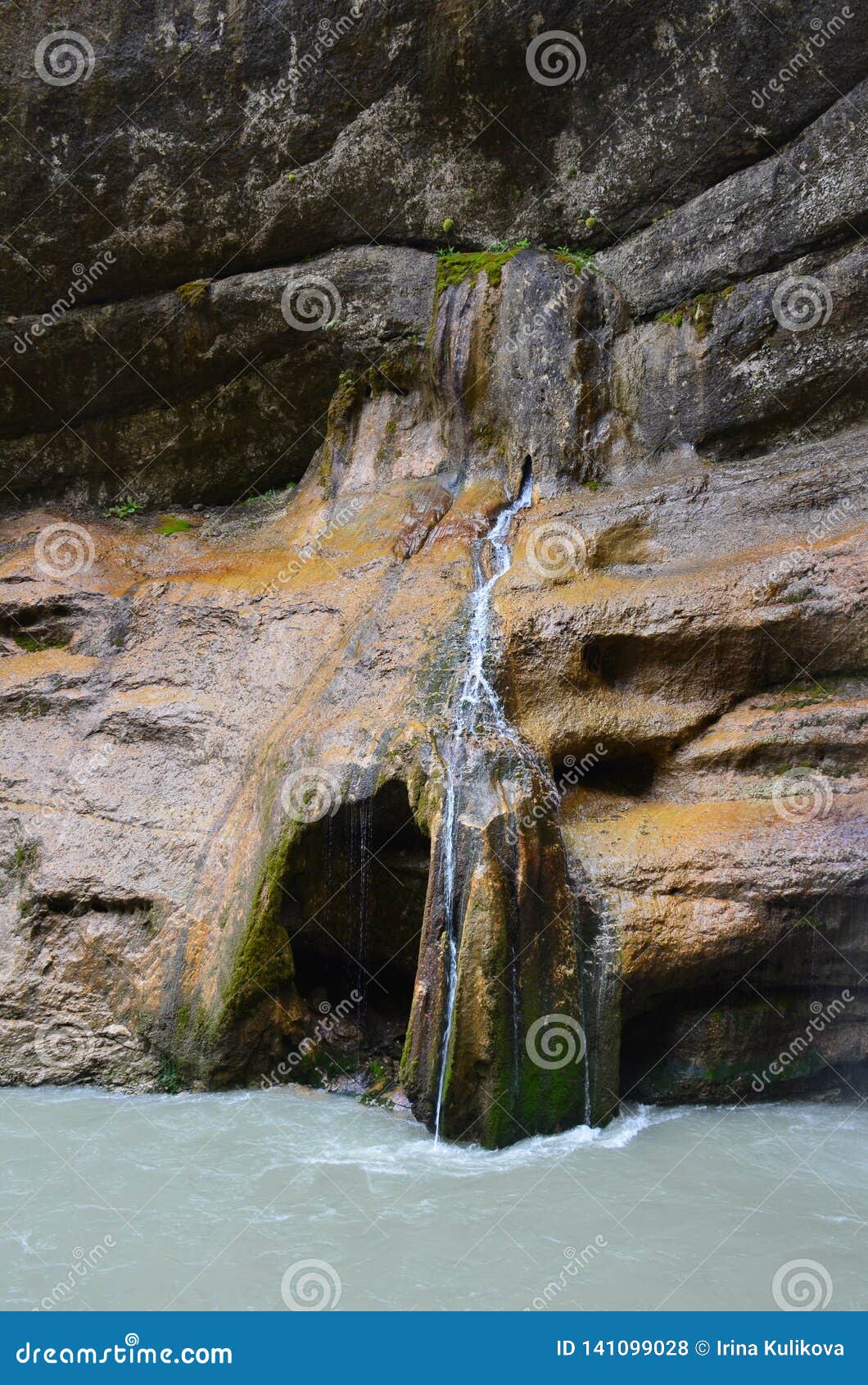 The Waterfall Flows Down a Thin Stream Over a Rock and Falls into a ...