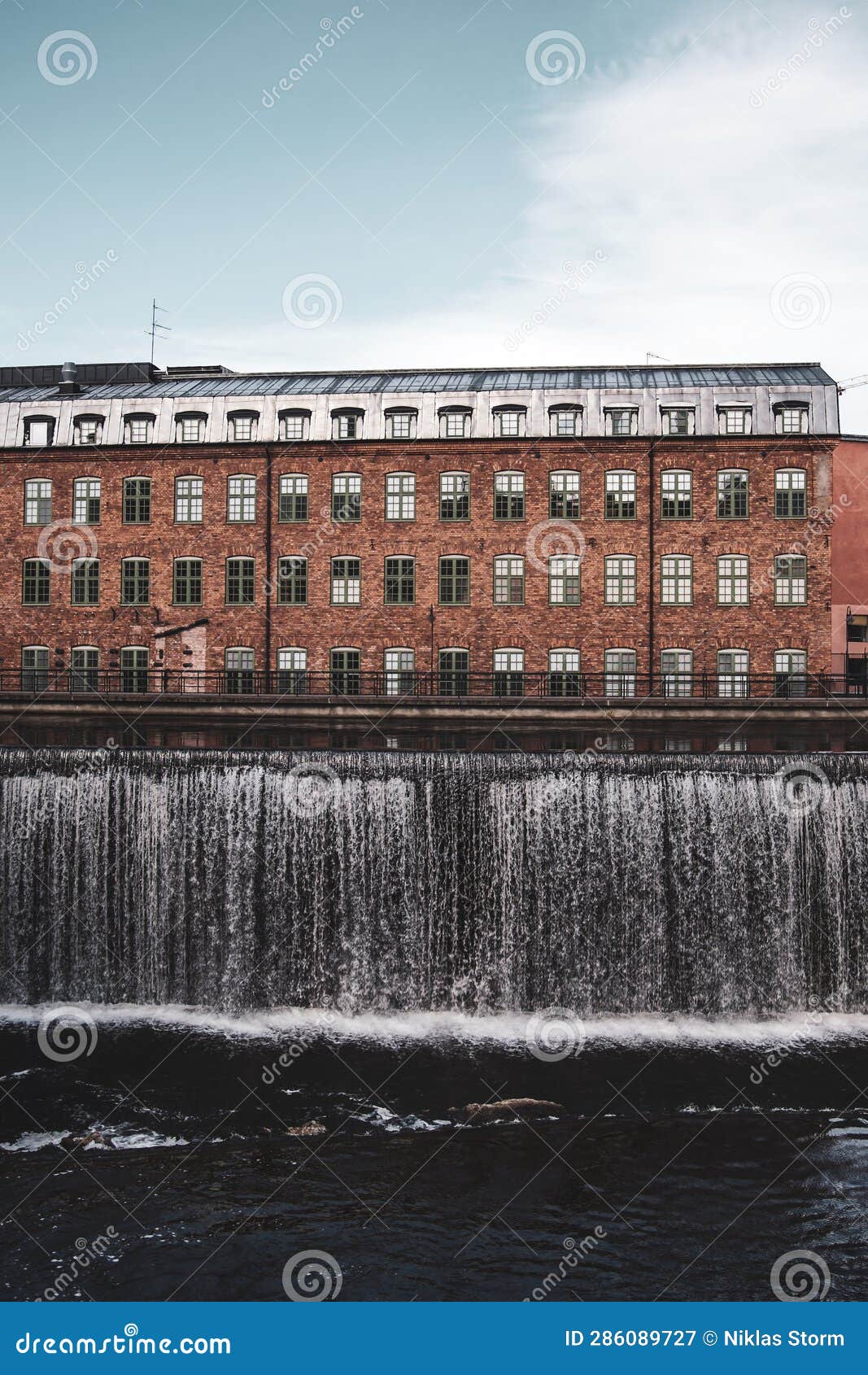 A Waterfall in Front of a Brick Building Stock Image - Image of ...