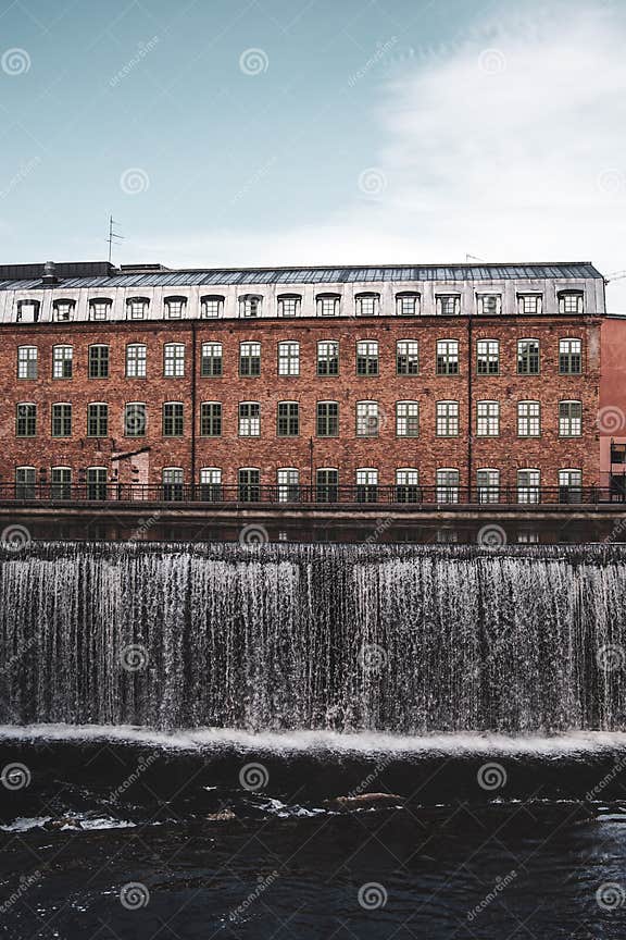 A Waterfall in Front of a Brick Building Stock Image - Image of ...
