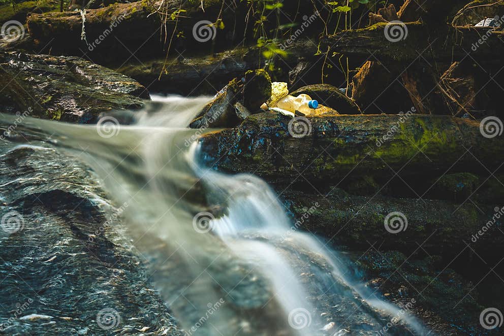 Waterfall with Plastic Waste Washed Up on a Rock. Stock Photo - Image ...