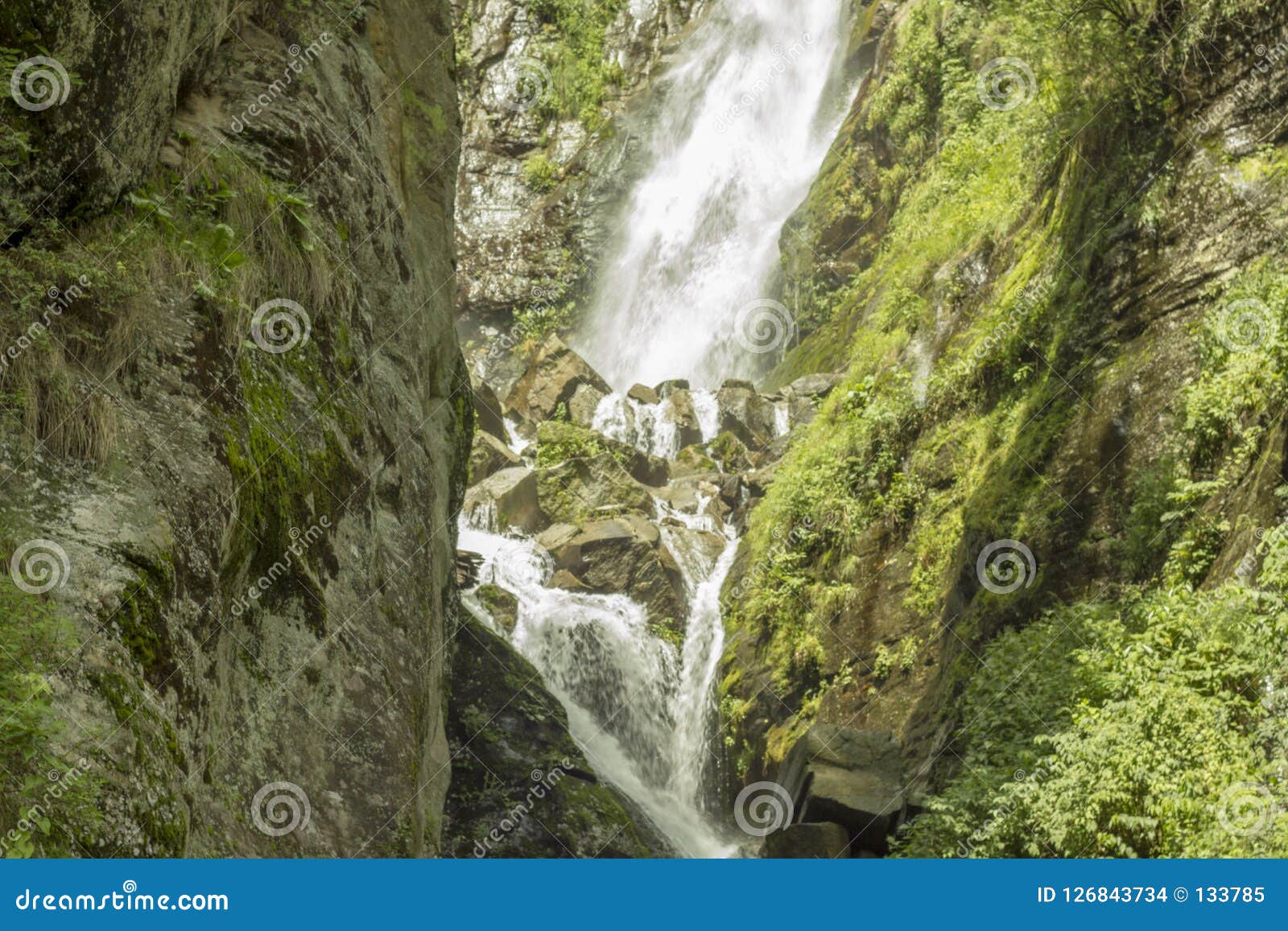 A Waterfall in the Rocks with Green Grass Stock Photo - Image of ...