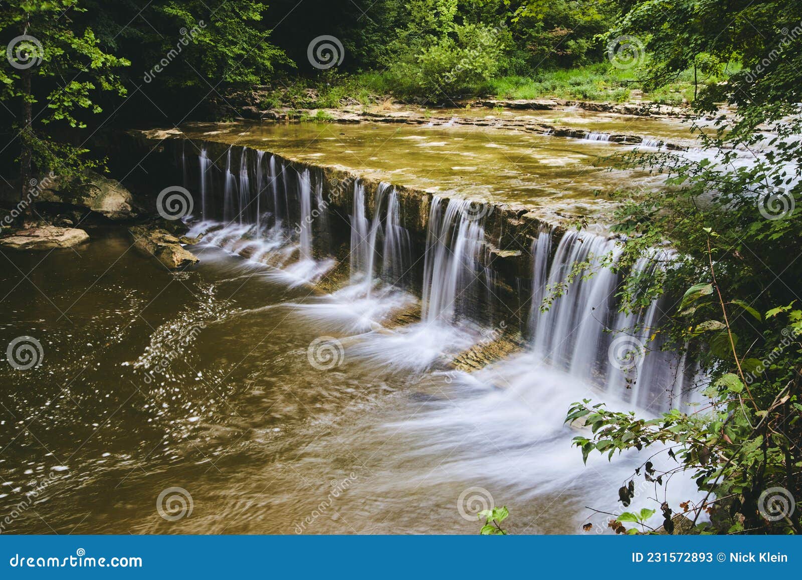 Waterfalls Over Wide River with Cliffs and Forest Stock Image - Image ...