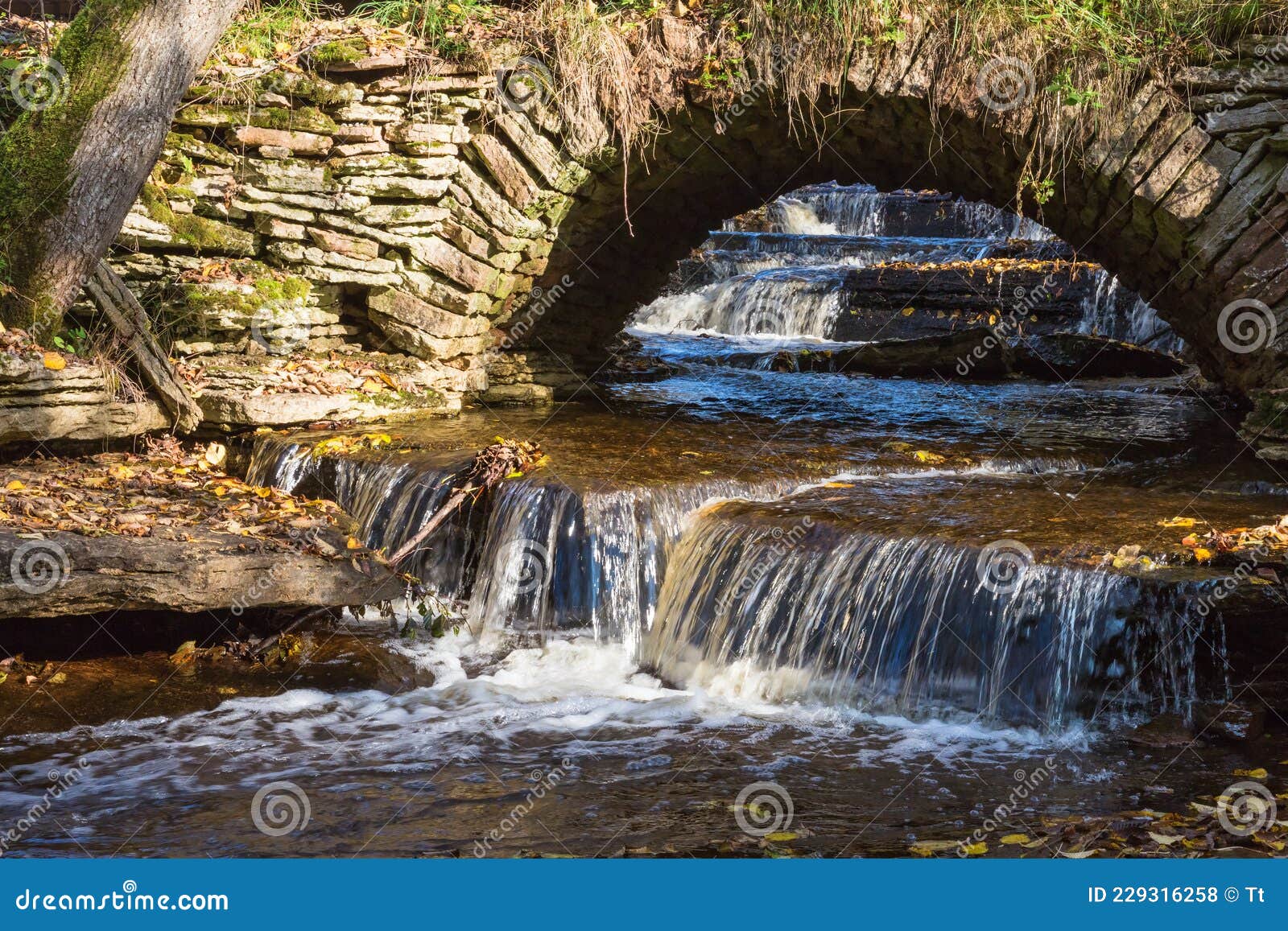 Waterfalls in the Stream with an Old Arch Bridge Stock Photo - Image of ...