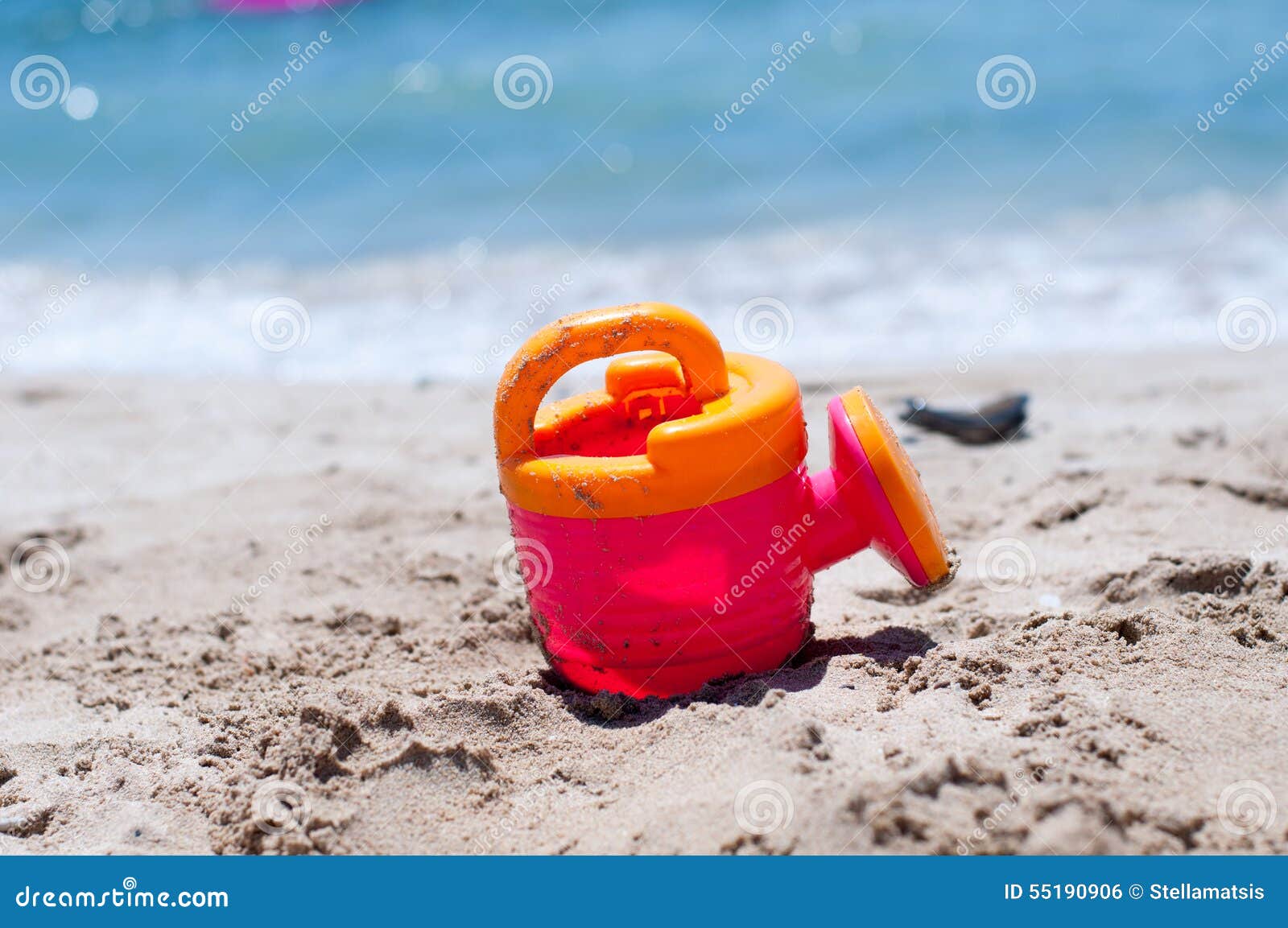 Watering can on the beach stock photo. Image of sand - 55190906
