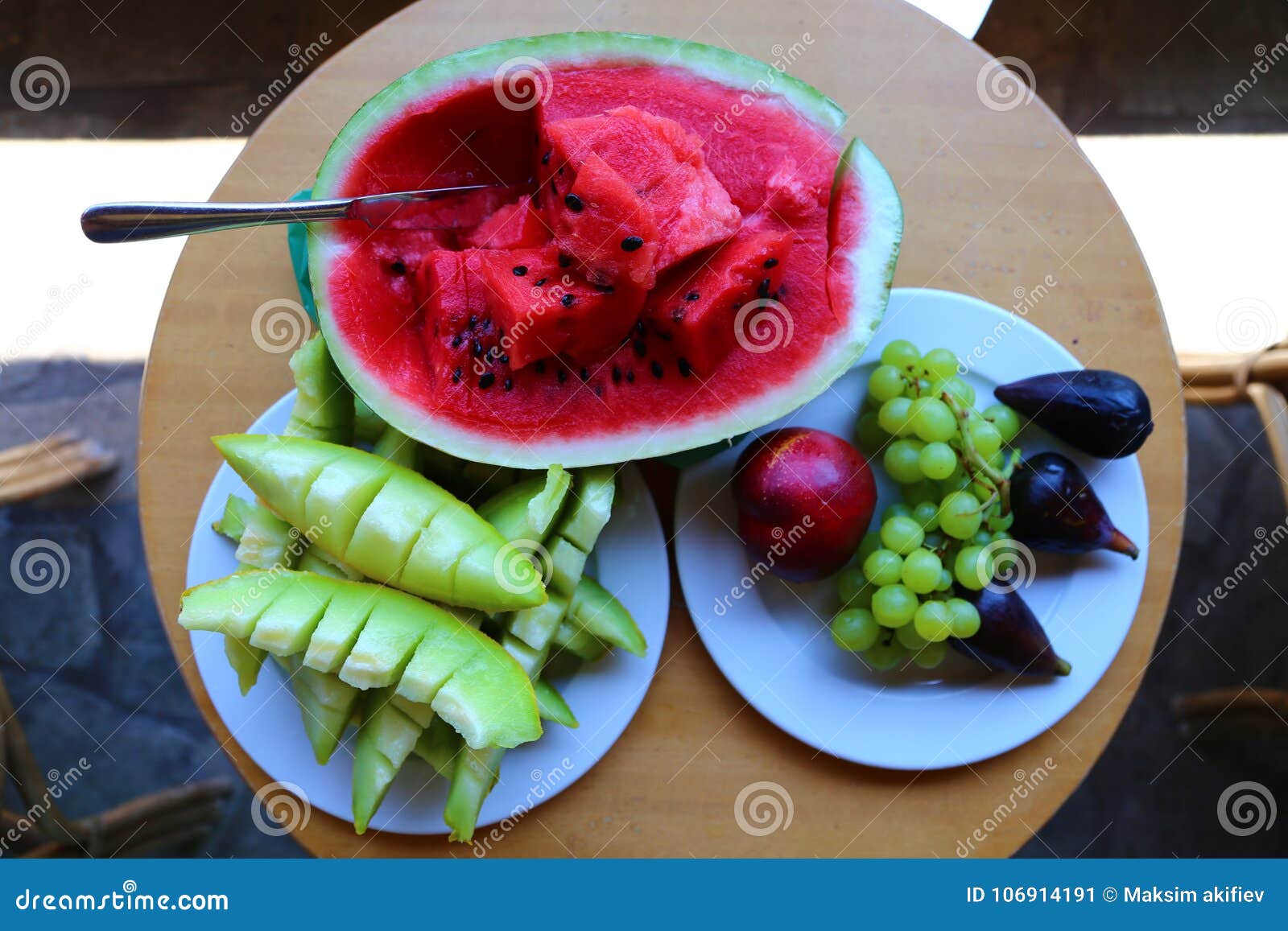 Watermelon, Melon and Grapes on Three Plates on a Wooden Table Stock ...