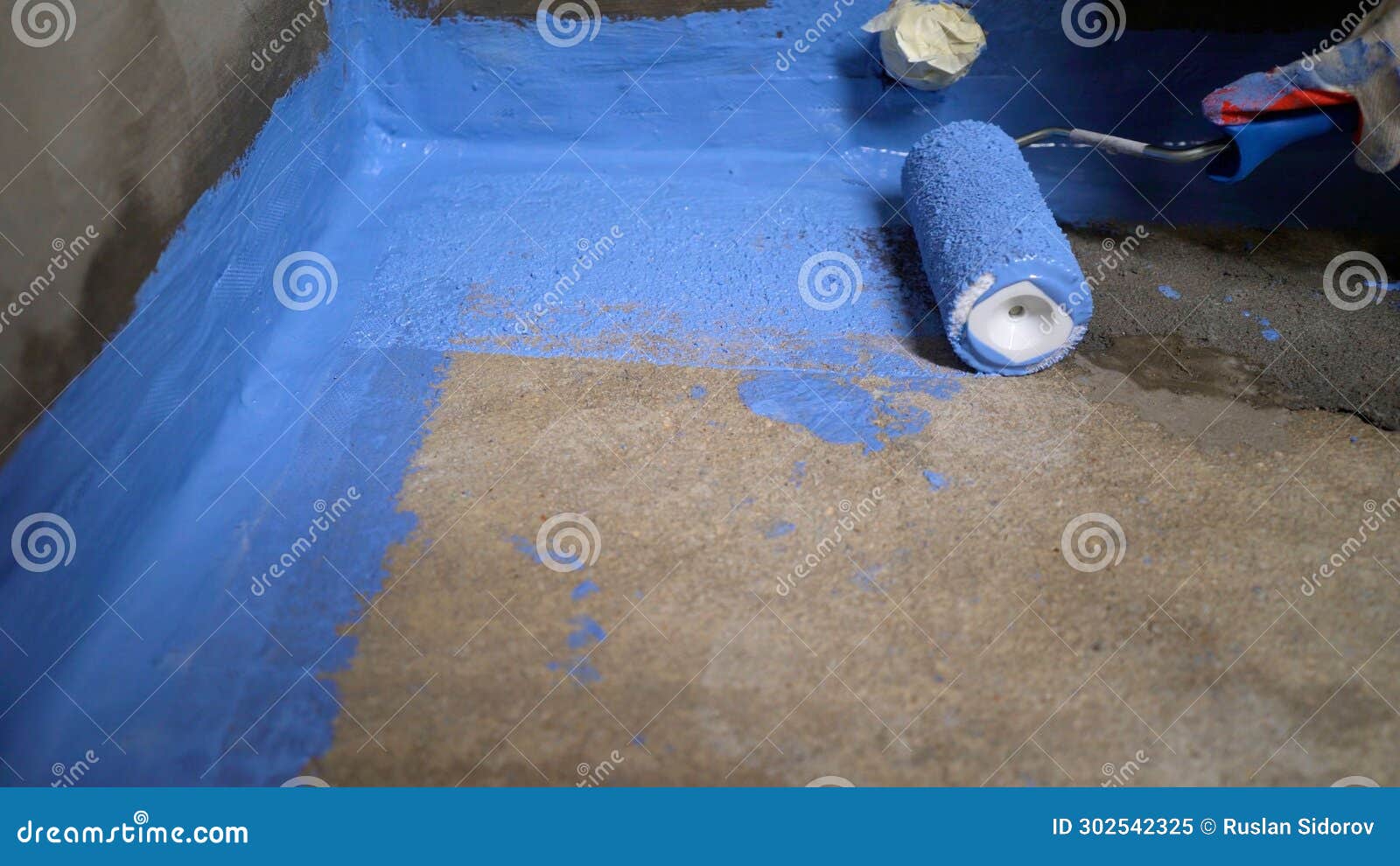 Paint Roller on a Partially Painted Floor. Waterproofing the Floor in ...