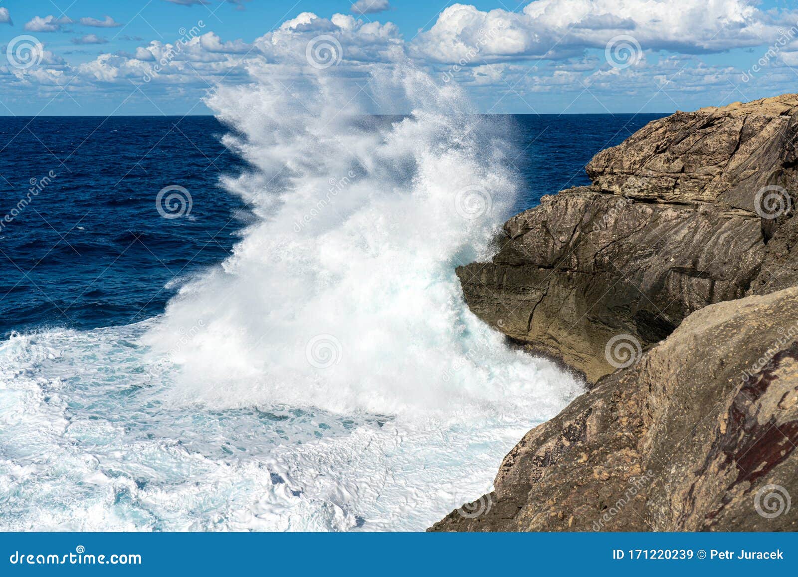 Wave breaking on a cliff stock image. Image of sunny - 171220239