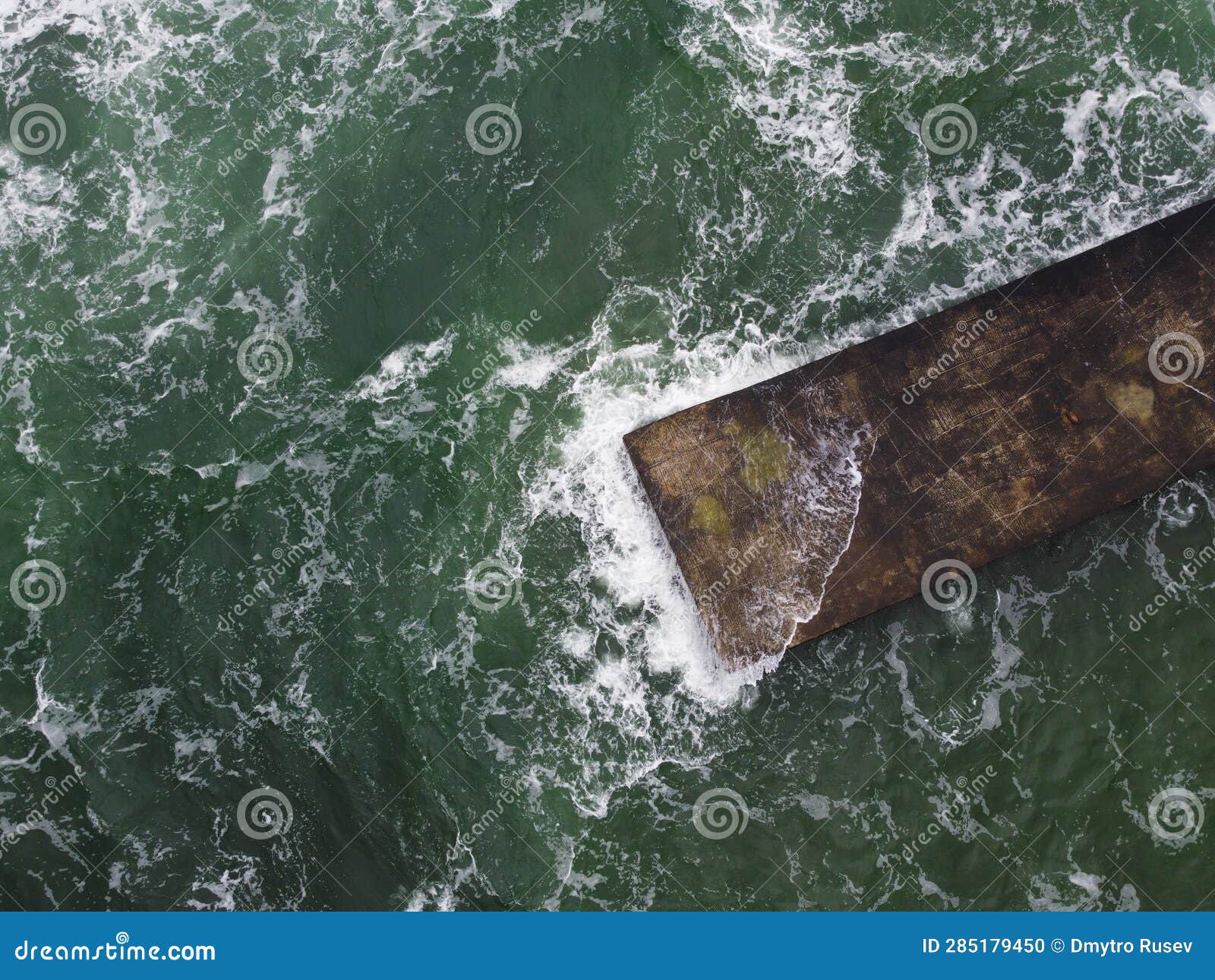 The Wave Rolls Over a Large Square Rock Lying on the Shore, Covered ...