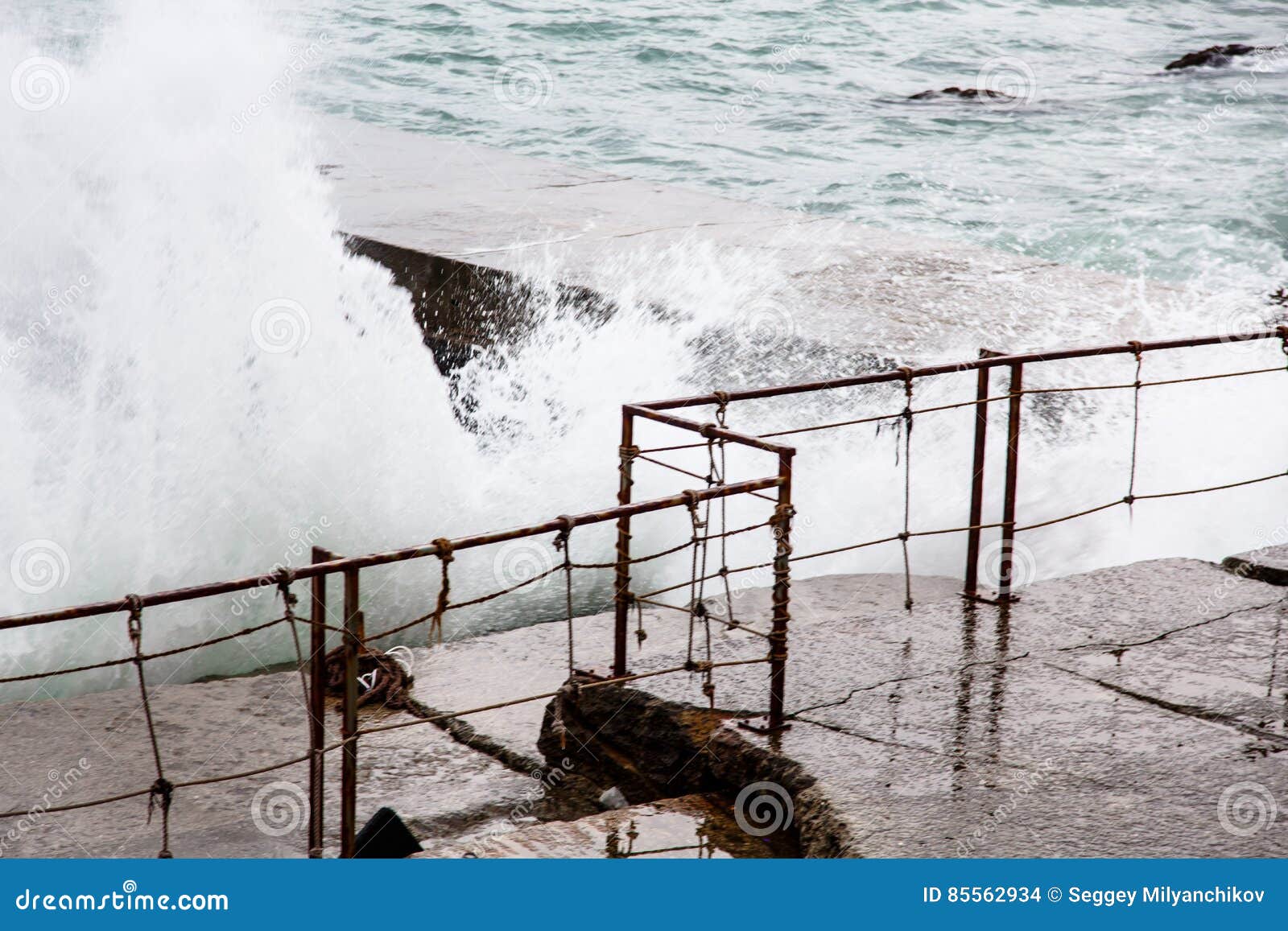 The Waves Break on the Old Jetty and the Rocks. Autumn is Overcast and ...