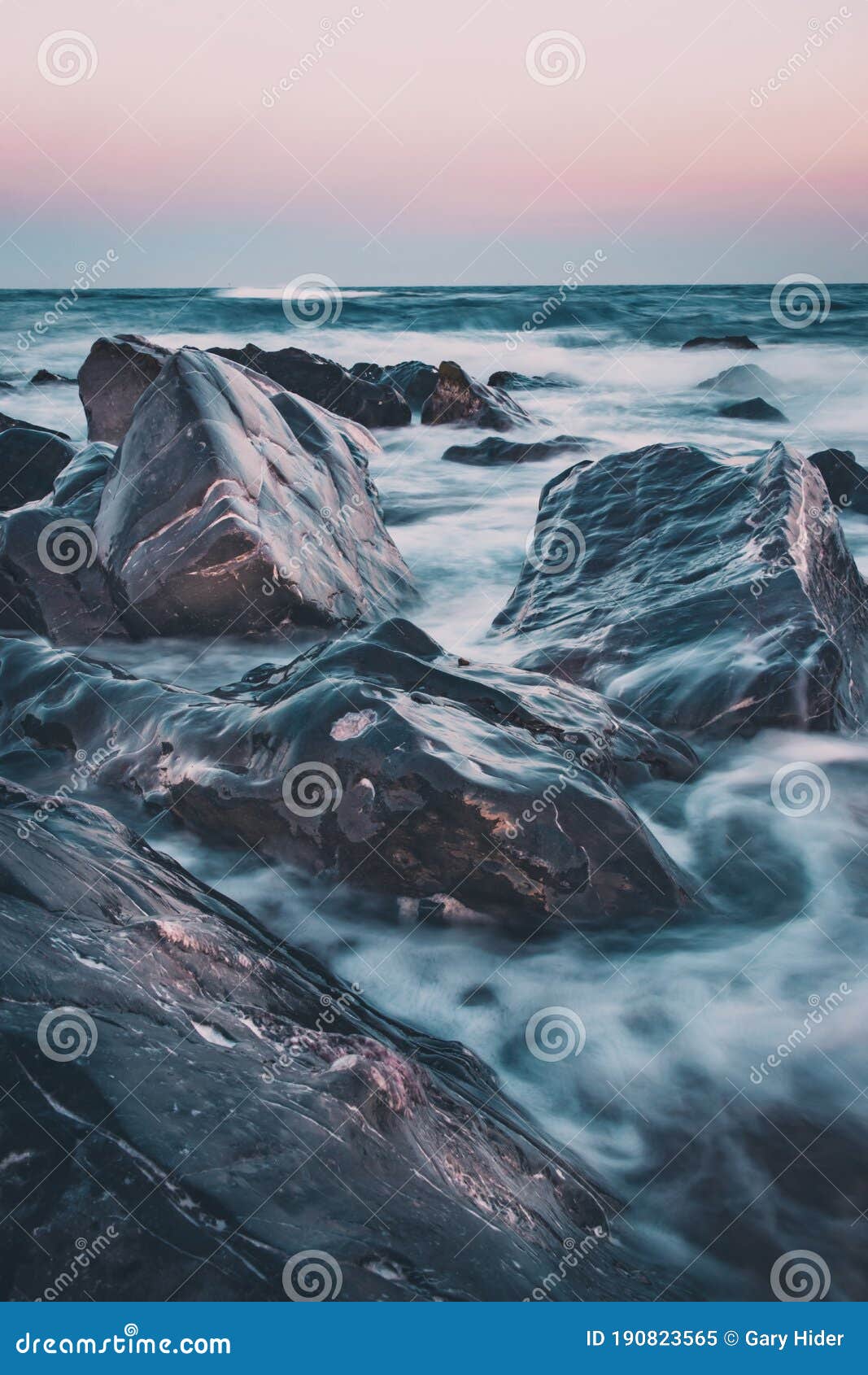 Waves Breaking Over Rocks at the Seaside during a Clear Sunset Stock ...