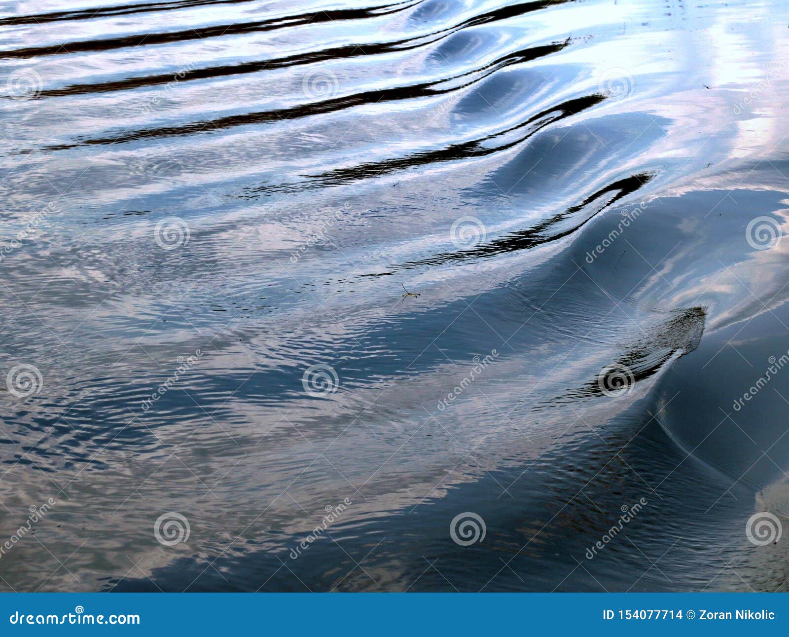Waves on the Surface of the Water Reflecting the Clouds Stock Photo ...